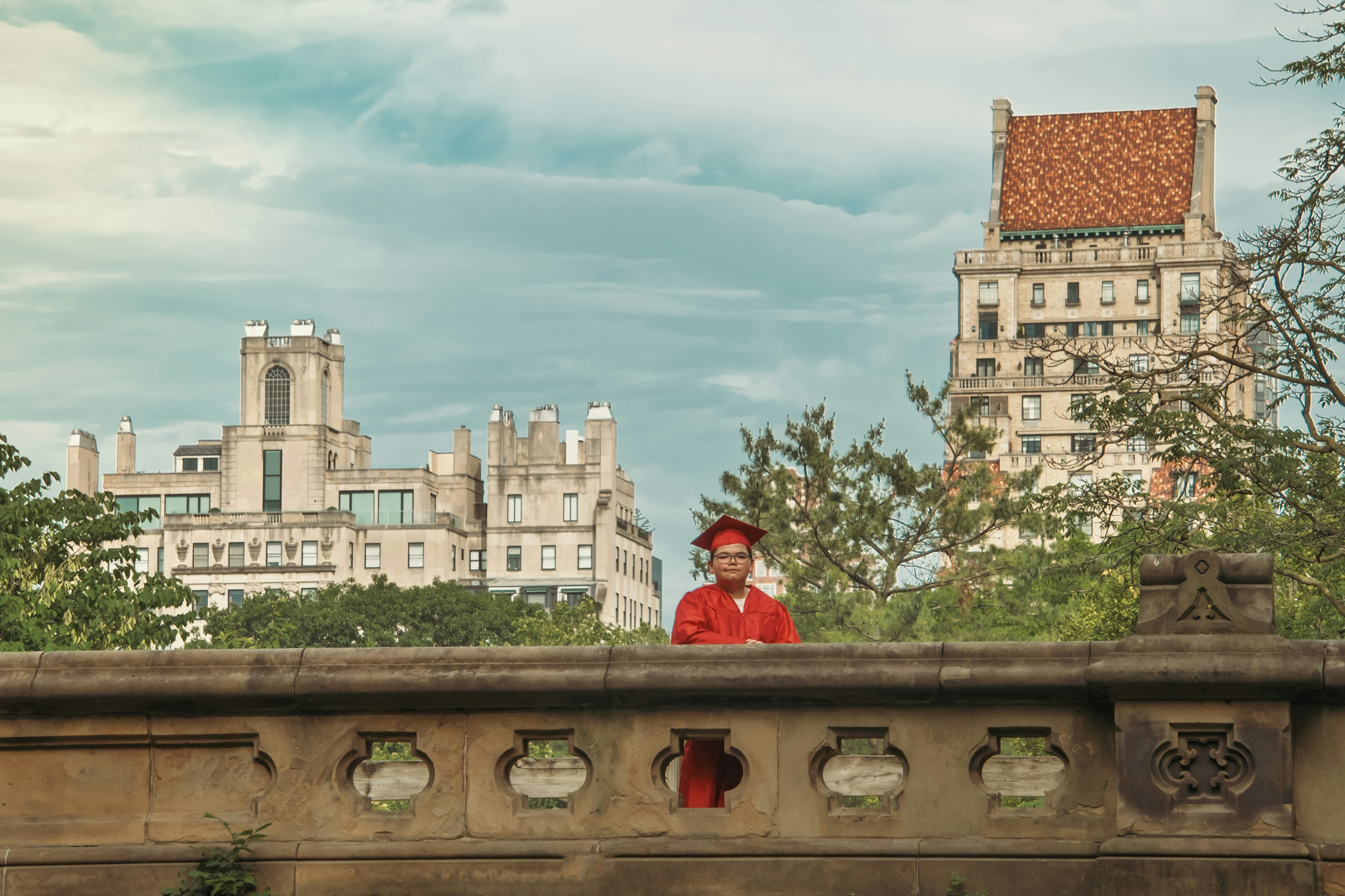 Graduate on the Bridge: A Red Gown Above the City