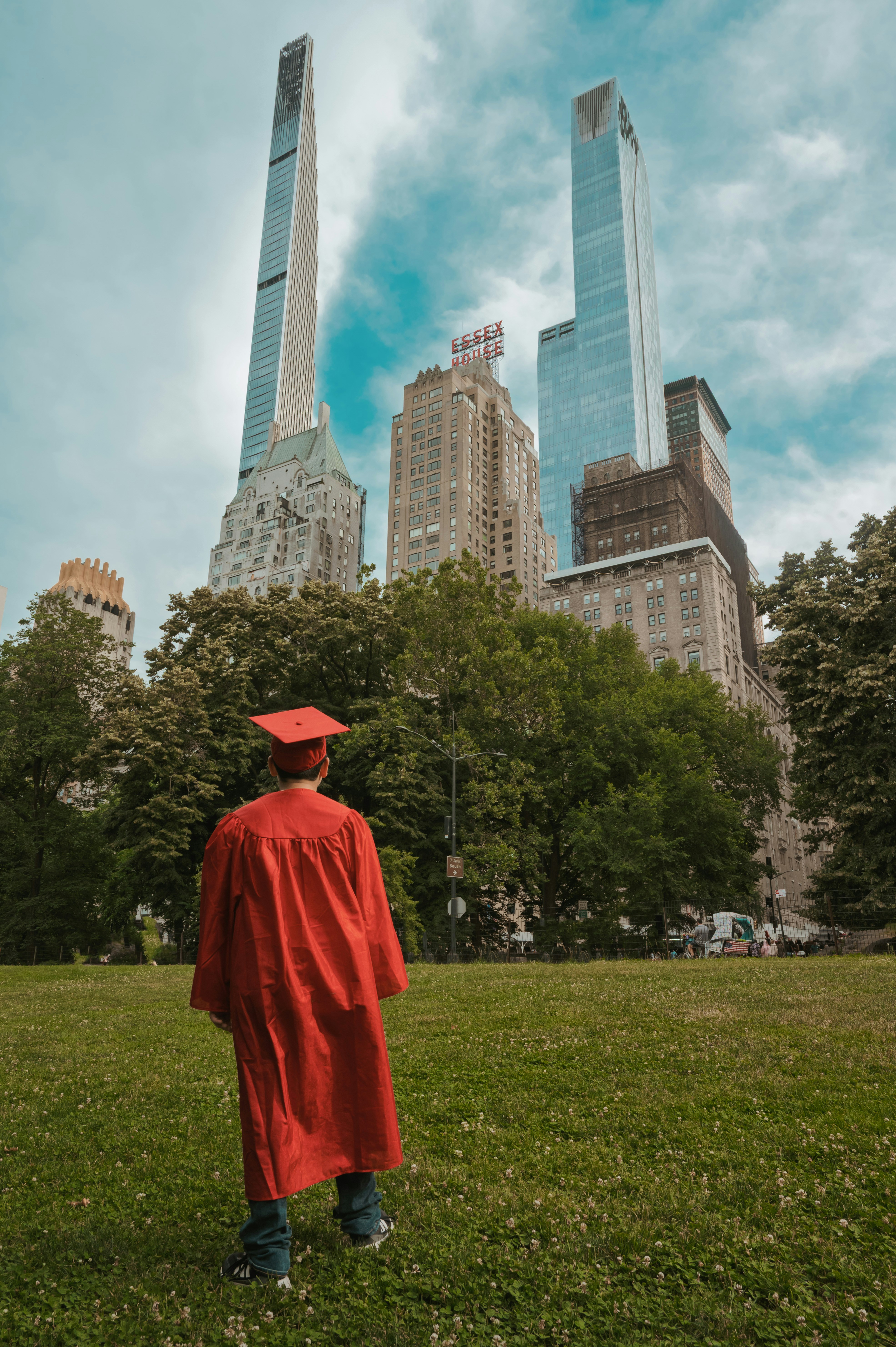 Red Graduation in the City Park: A Bannered Moment Before Skyscrapers