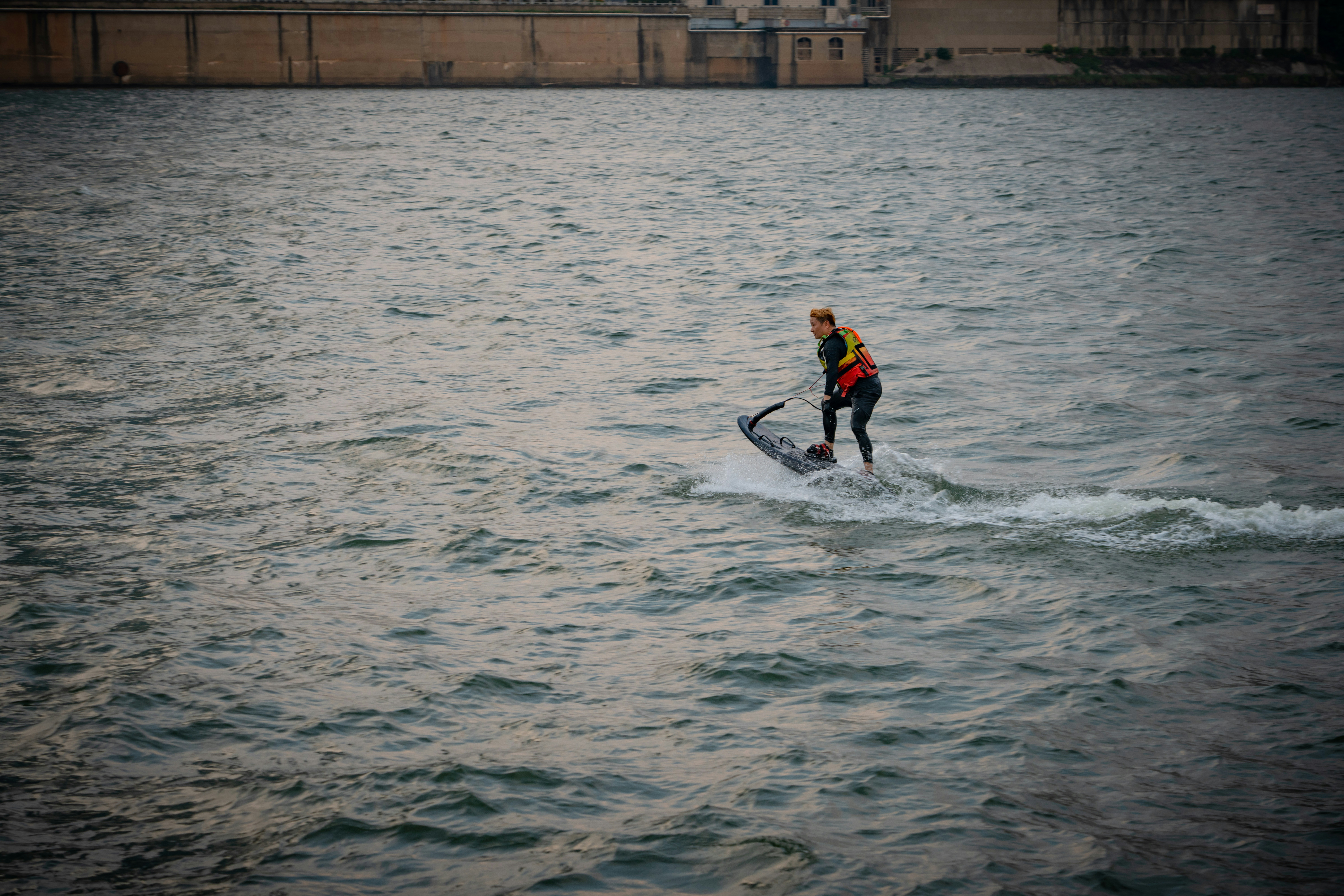 Splash of Dawn: Wakeboarder carving toward the break in the river