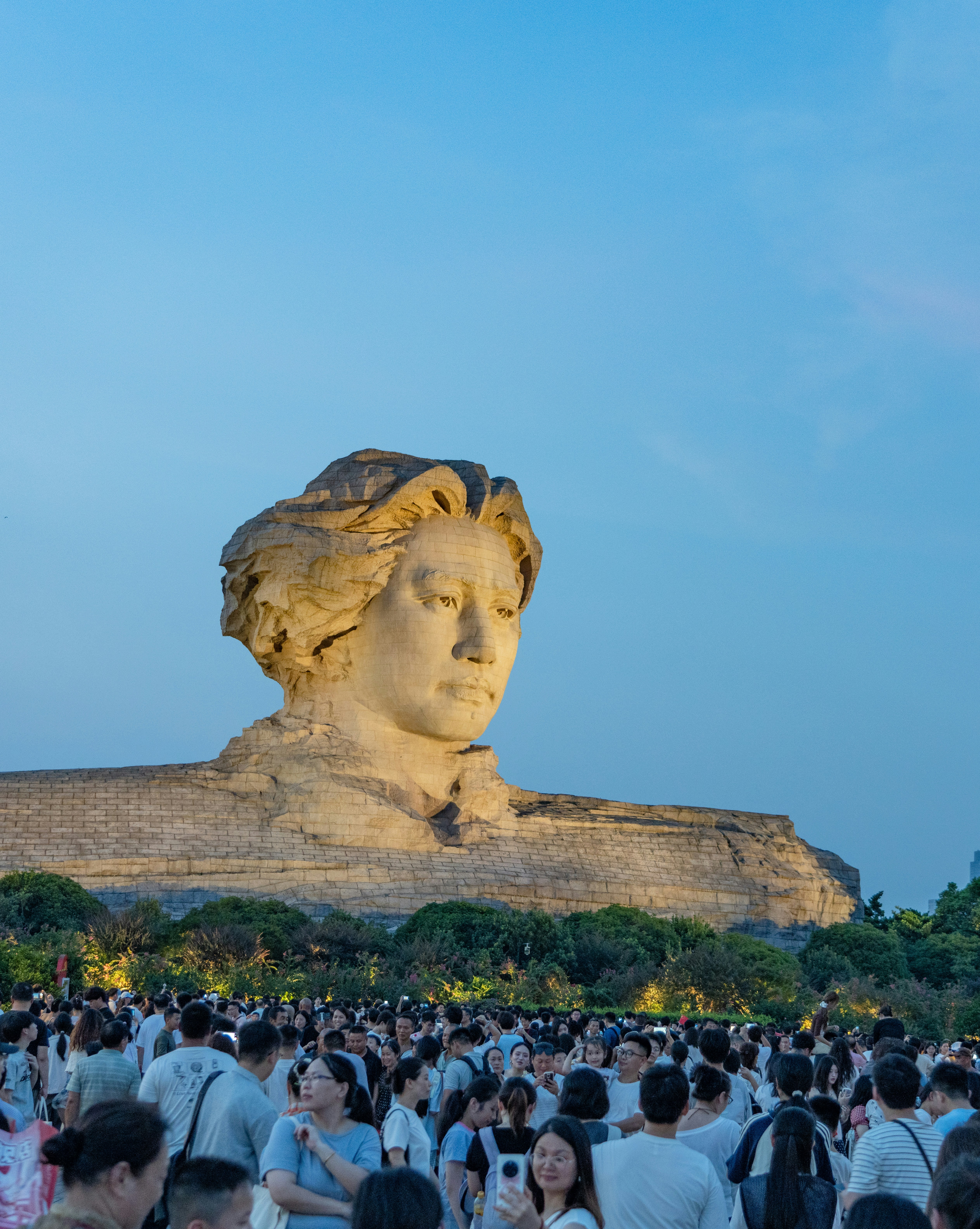 Whispers of Stone: The Giant Head Over the Sea of People