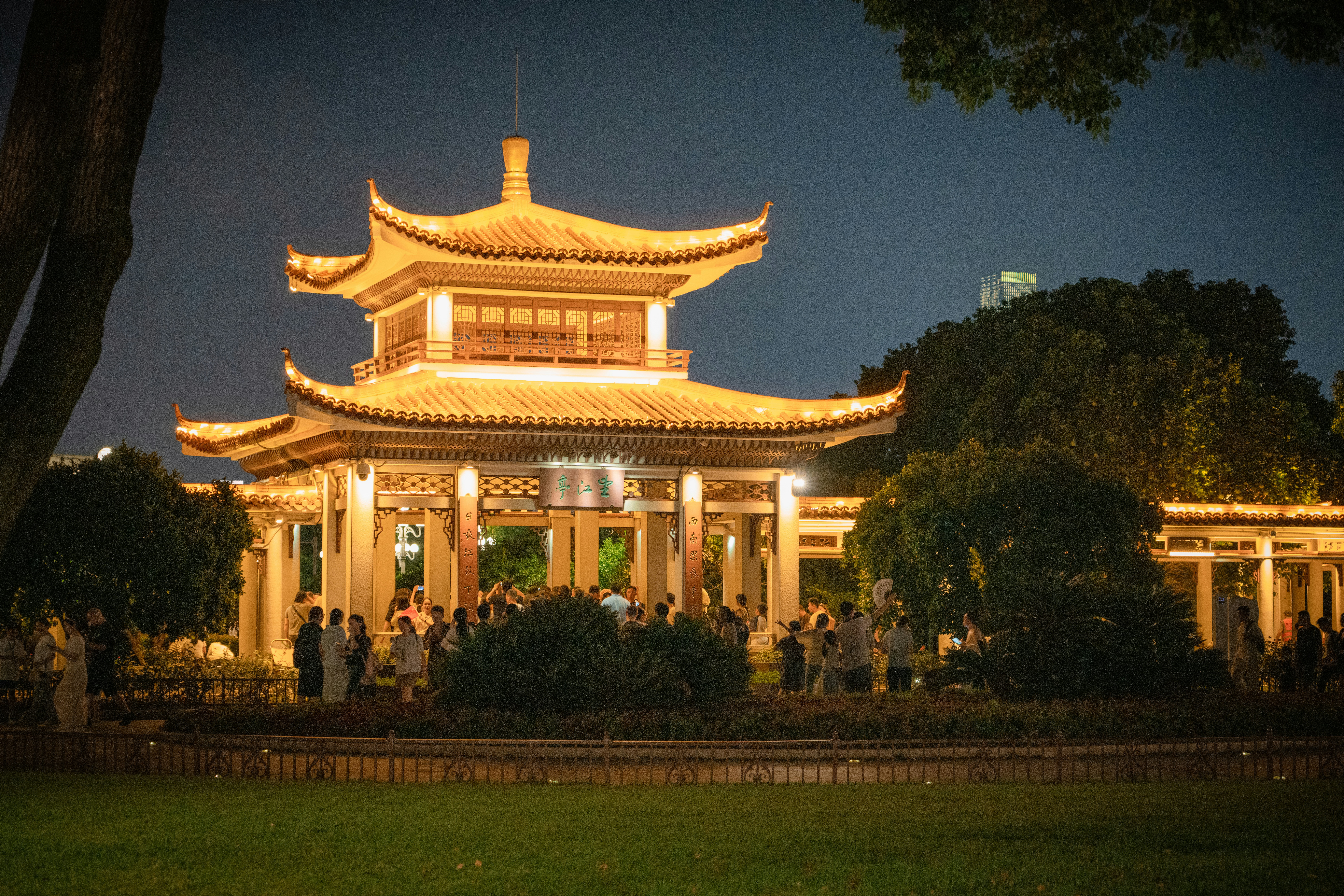 Golden Pavilion at Night: Lanterns, People, and Soft Glow