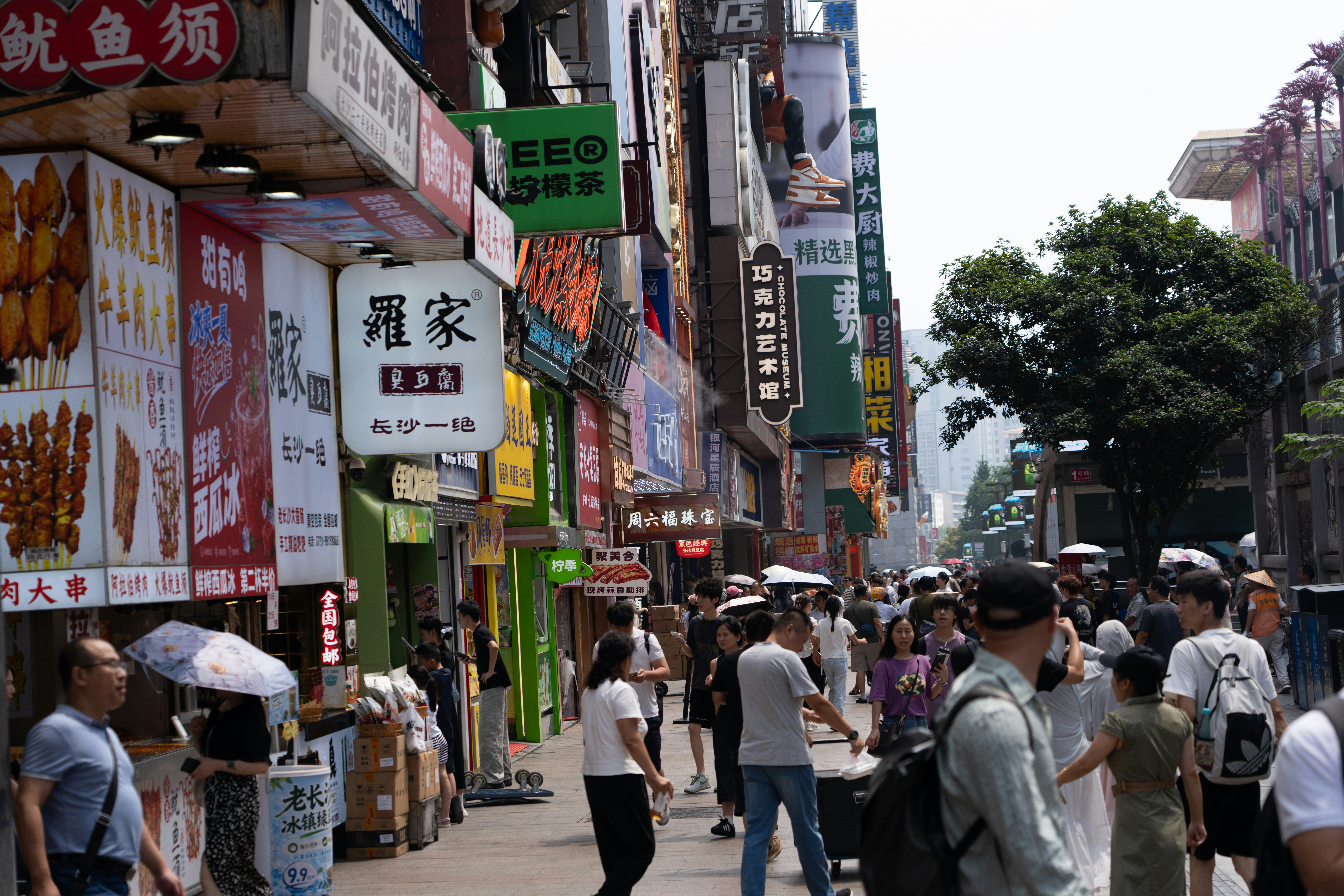 Bustling Street Market Lines: Signs, Shoppers, and Snack Stalls