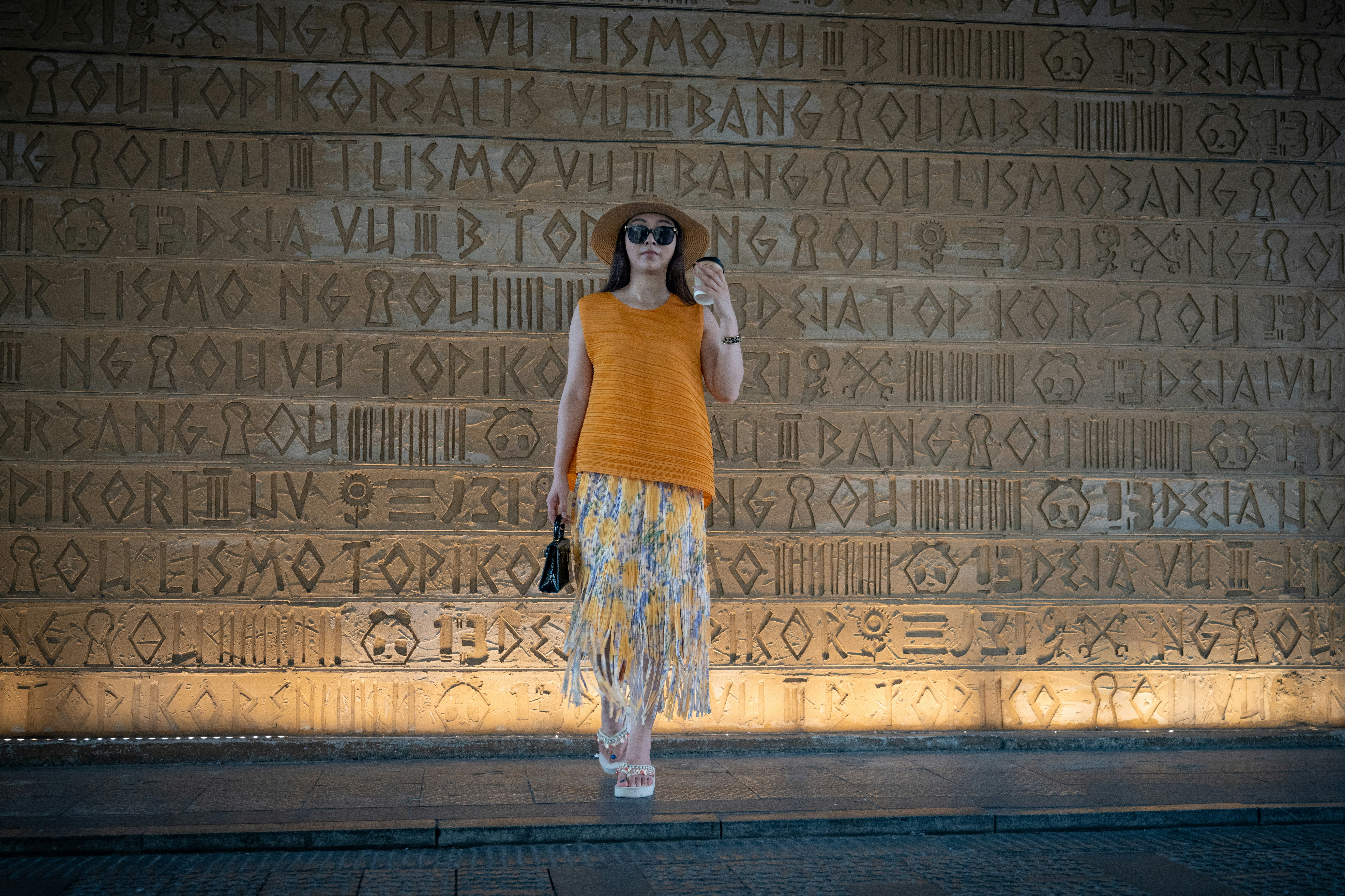 Sunlit orange dress met by carved stone: a stroll through history
