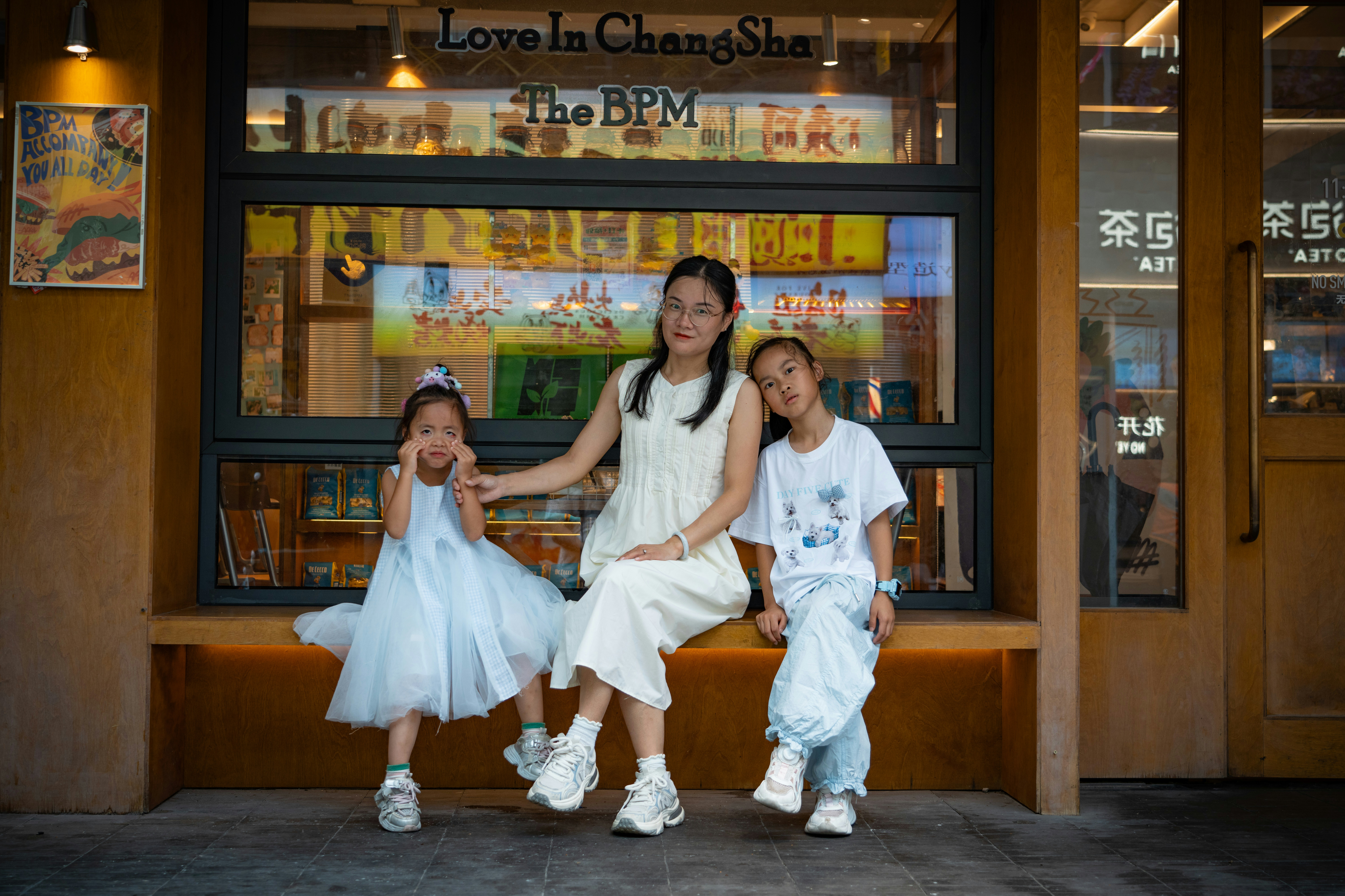 Three Generations in a Row: A Moment on the Shopfront Bench