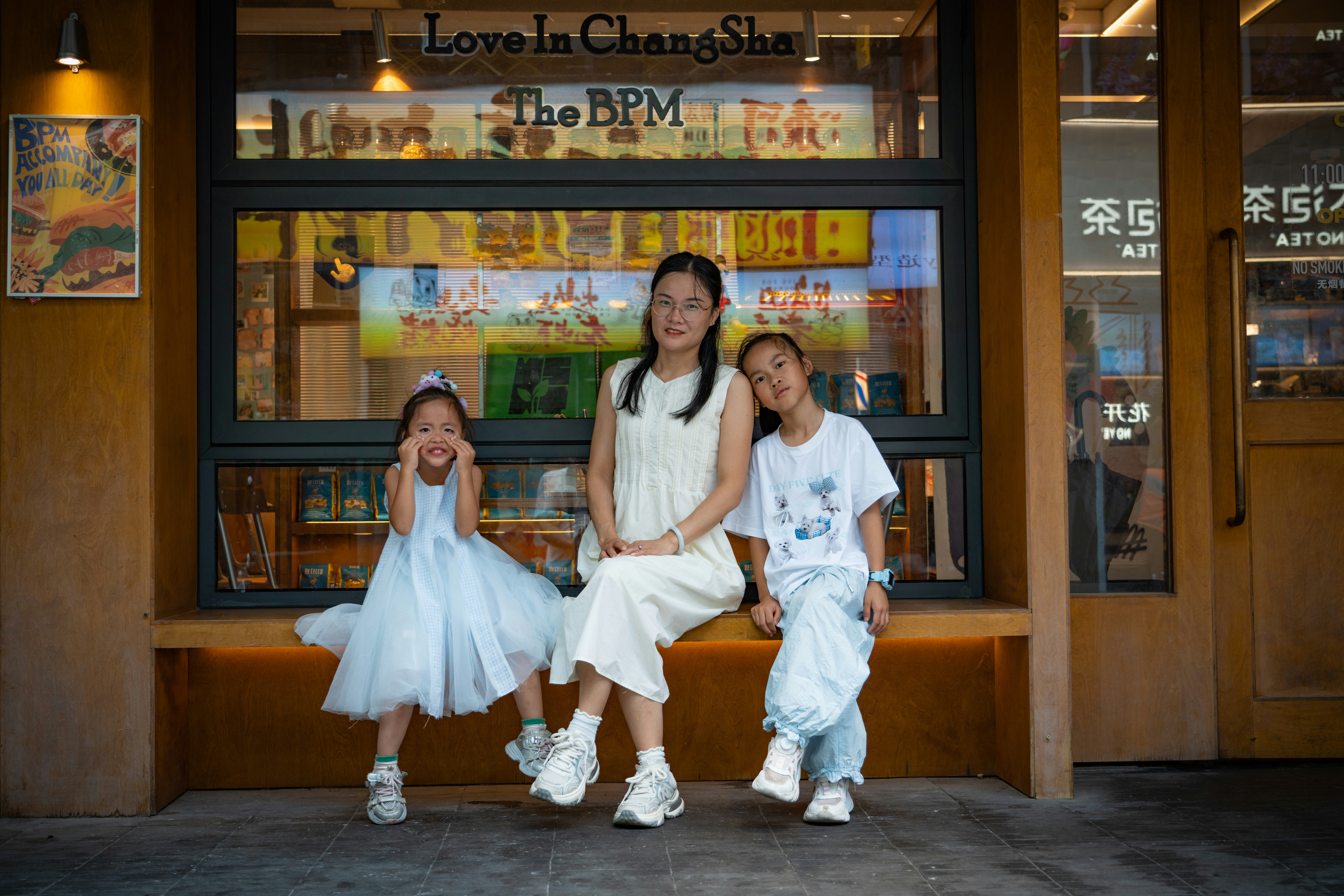 Three Generations of Grace: A Quiet Moment on a Windowed Bench