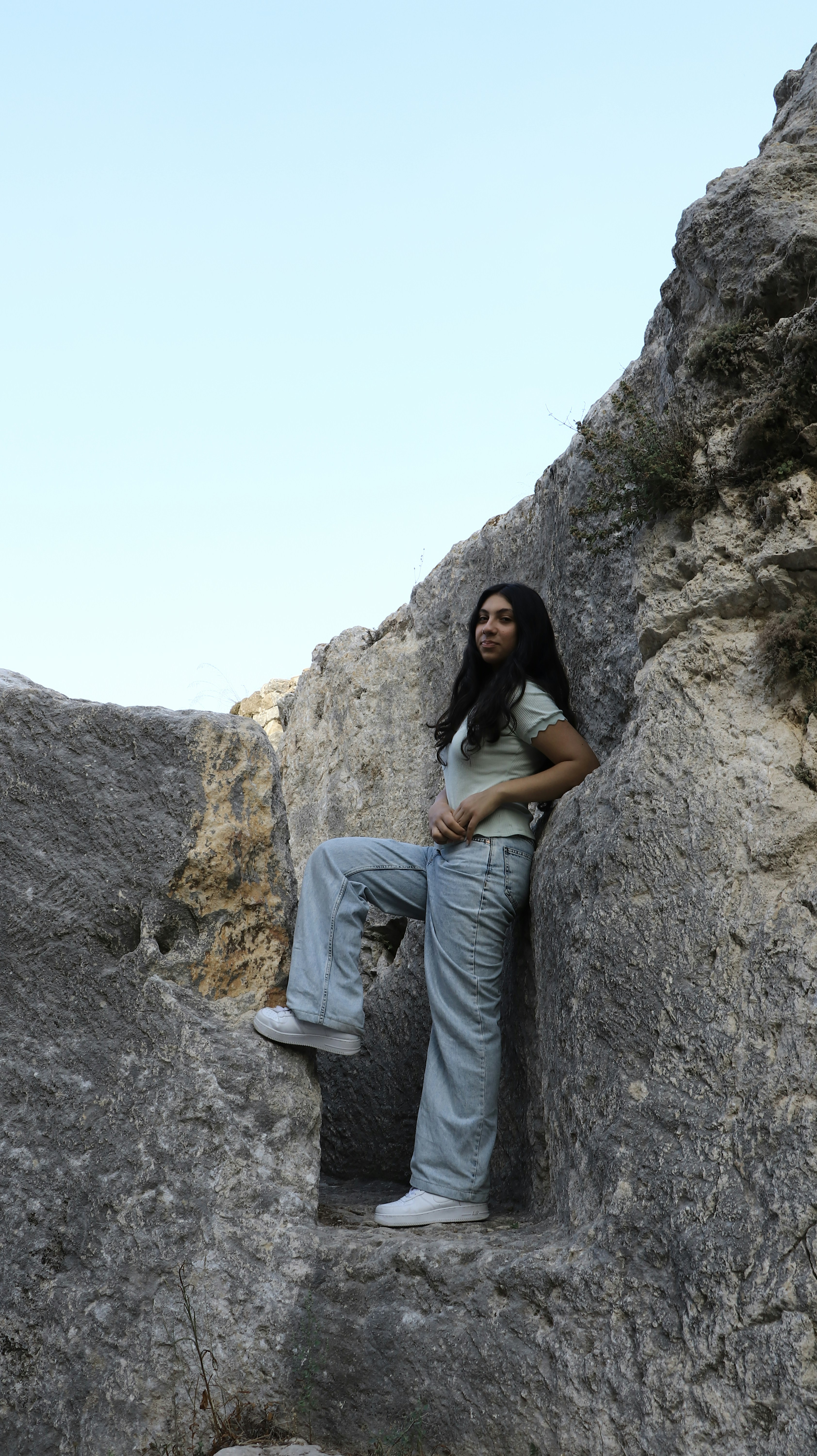 Cliffside stance: a lone figure courts the sky from a rocky ledge