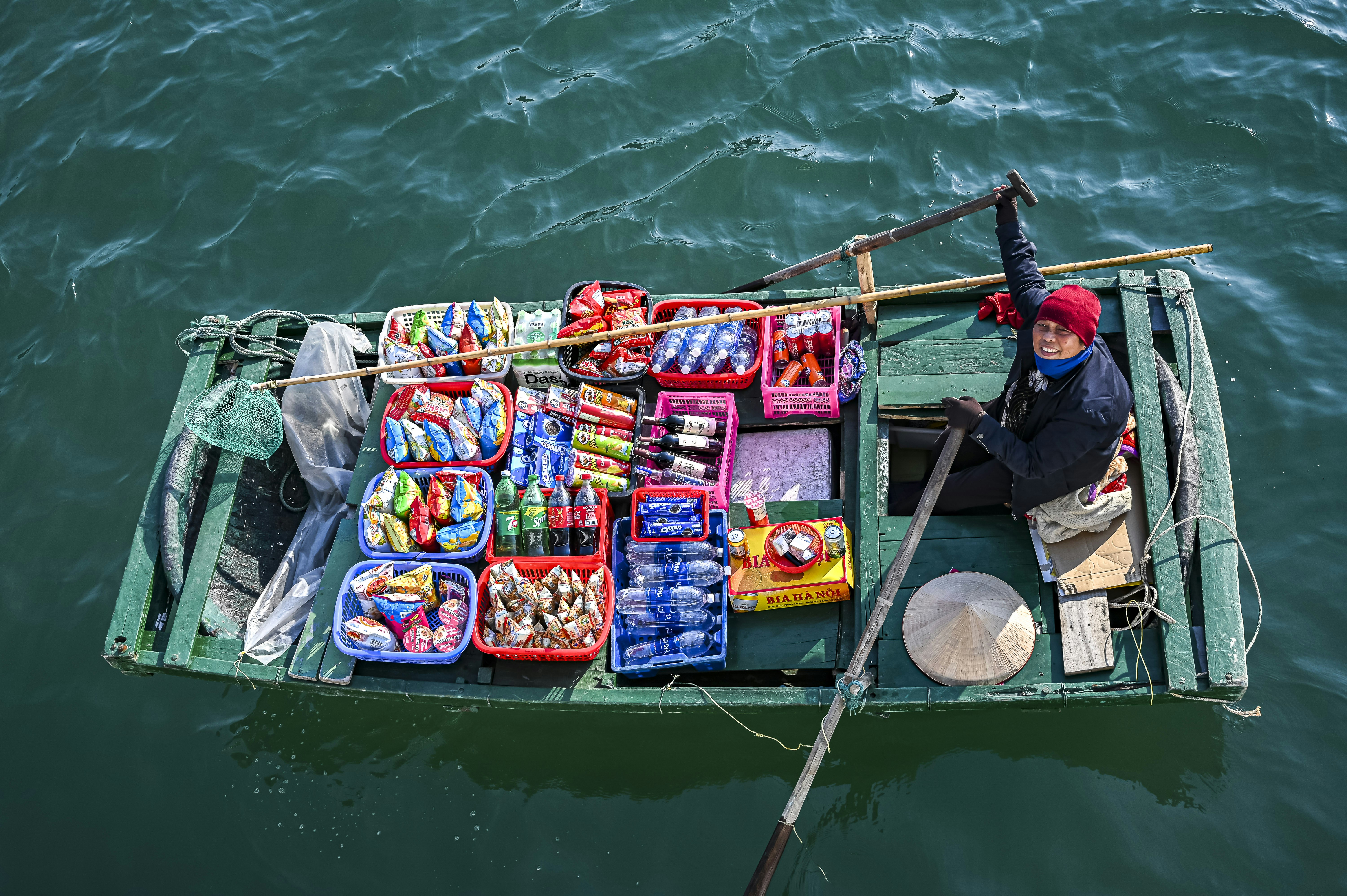 Floating Market: A lone vendor in a vivid cargo boat amid turquoise waters