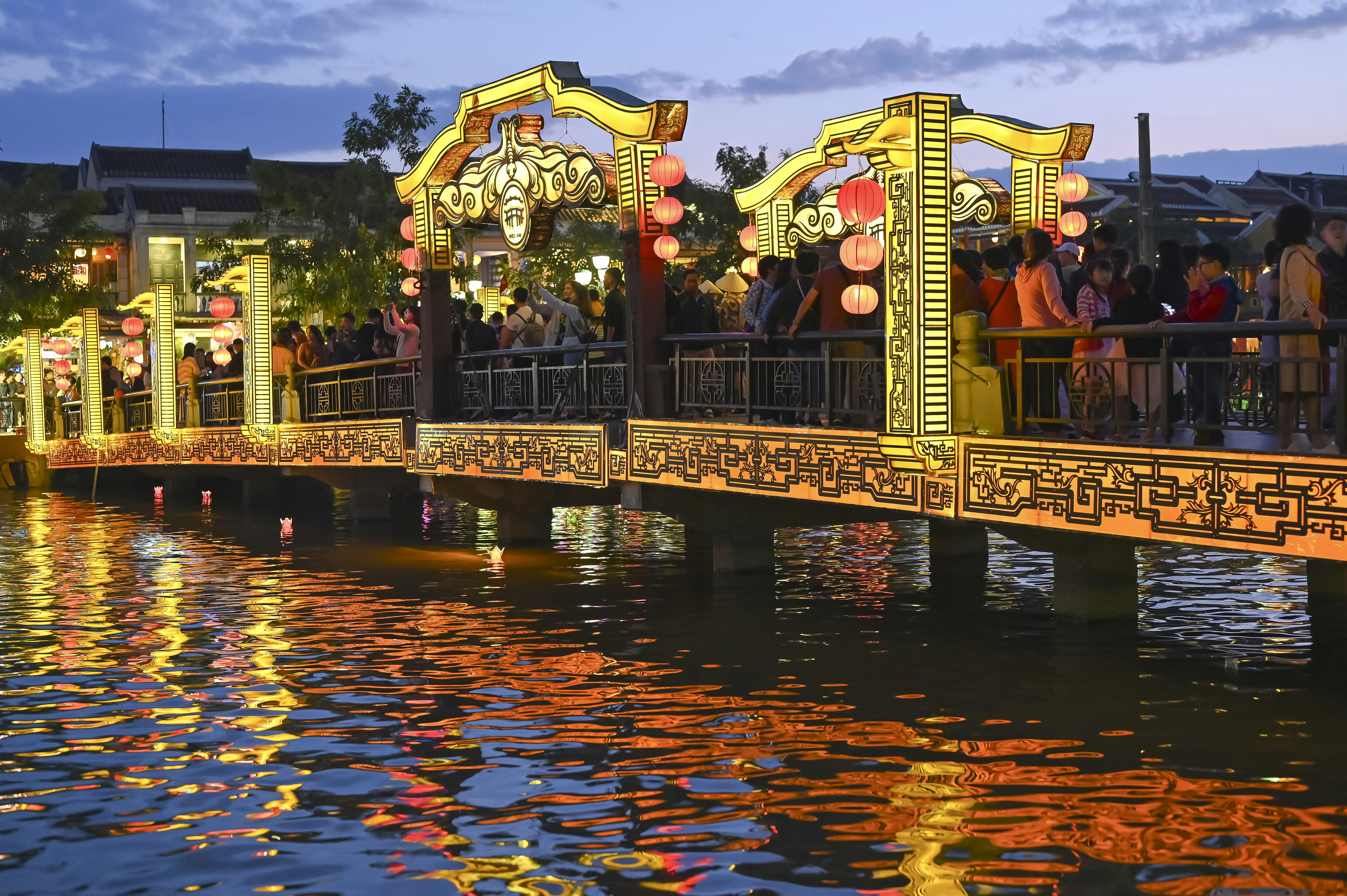 Illuminated Chinese terrace over shimmering water at dusk
