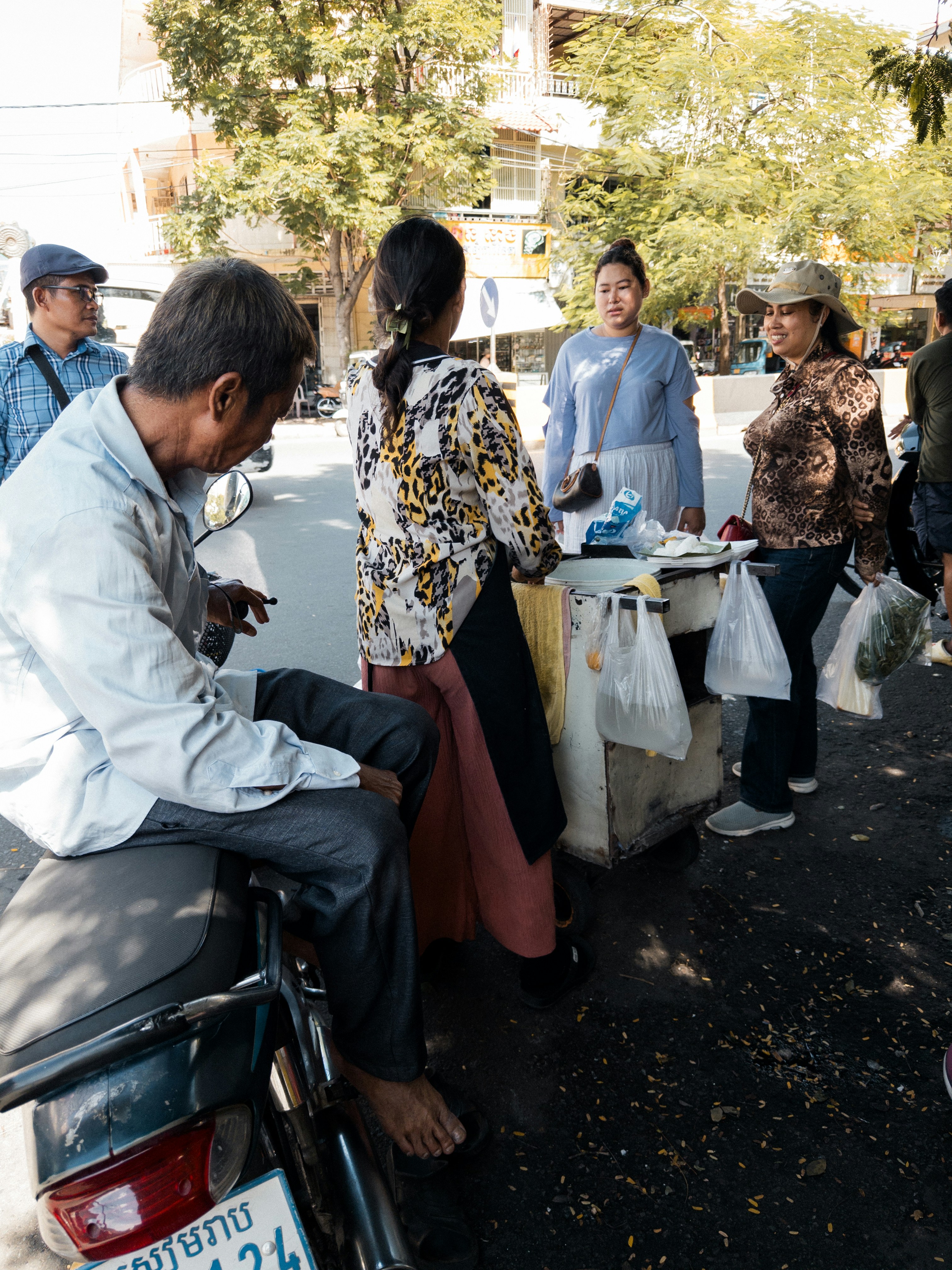 Street Market Portrait at Dusk: People Gather Around a Vendor Stand