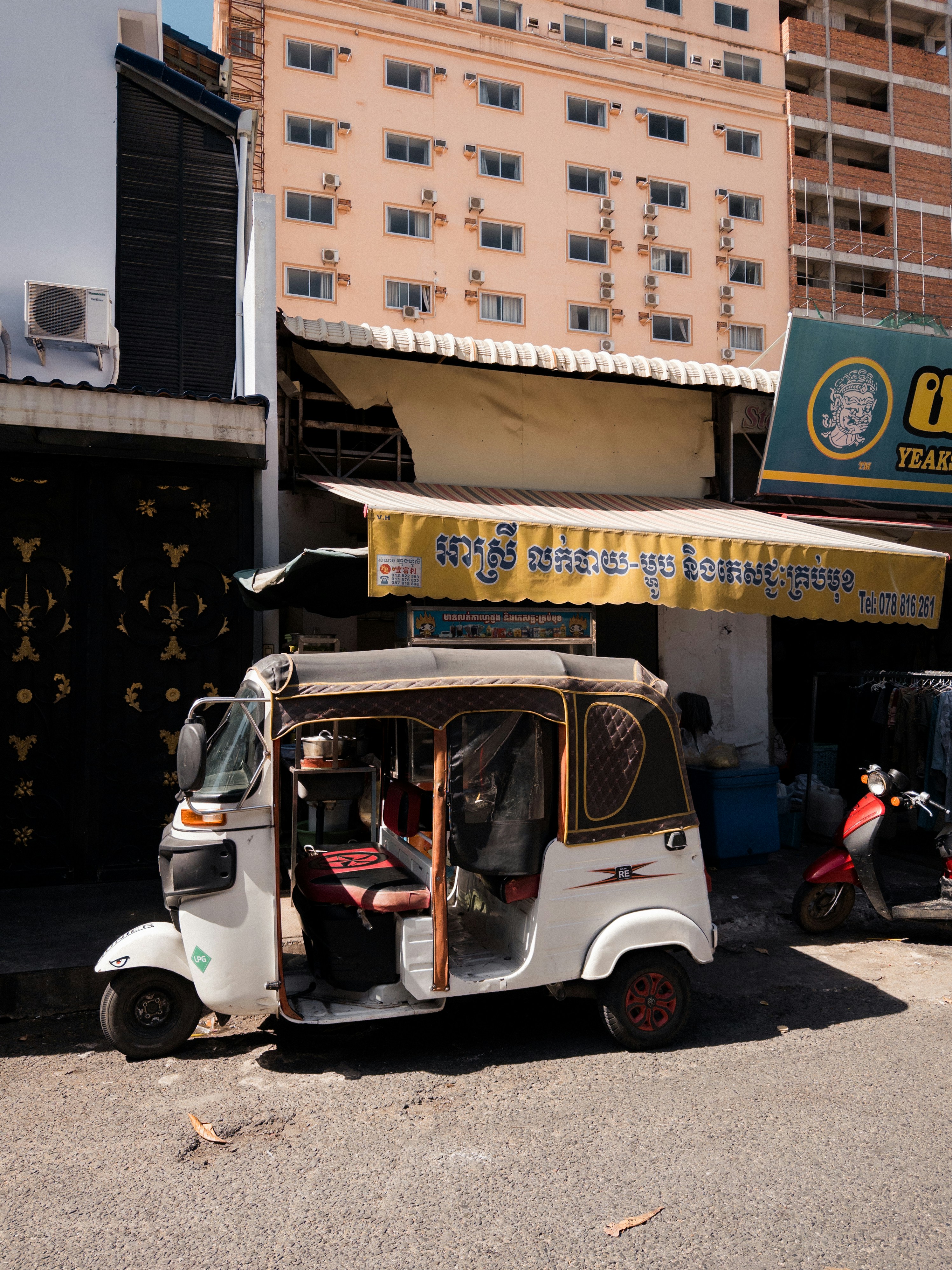 Three-Wedged Rikska: A Street-Side Auto Rickshaw Under Neon Canopy