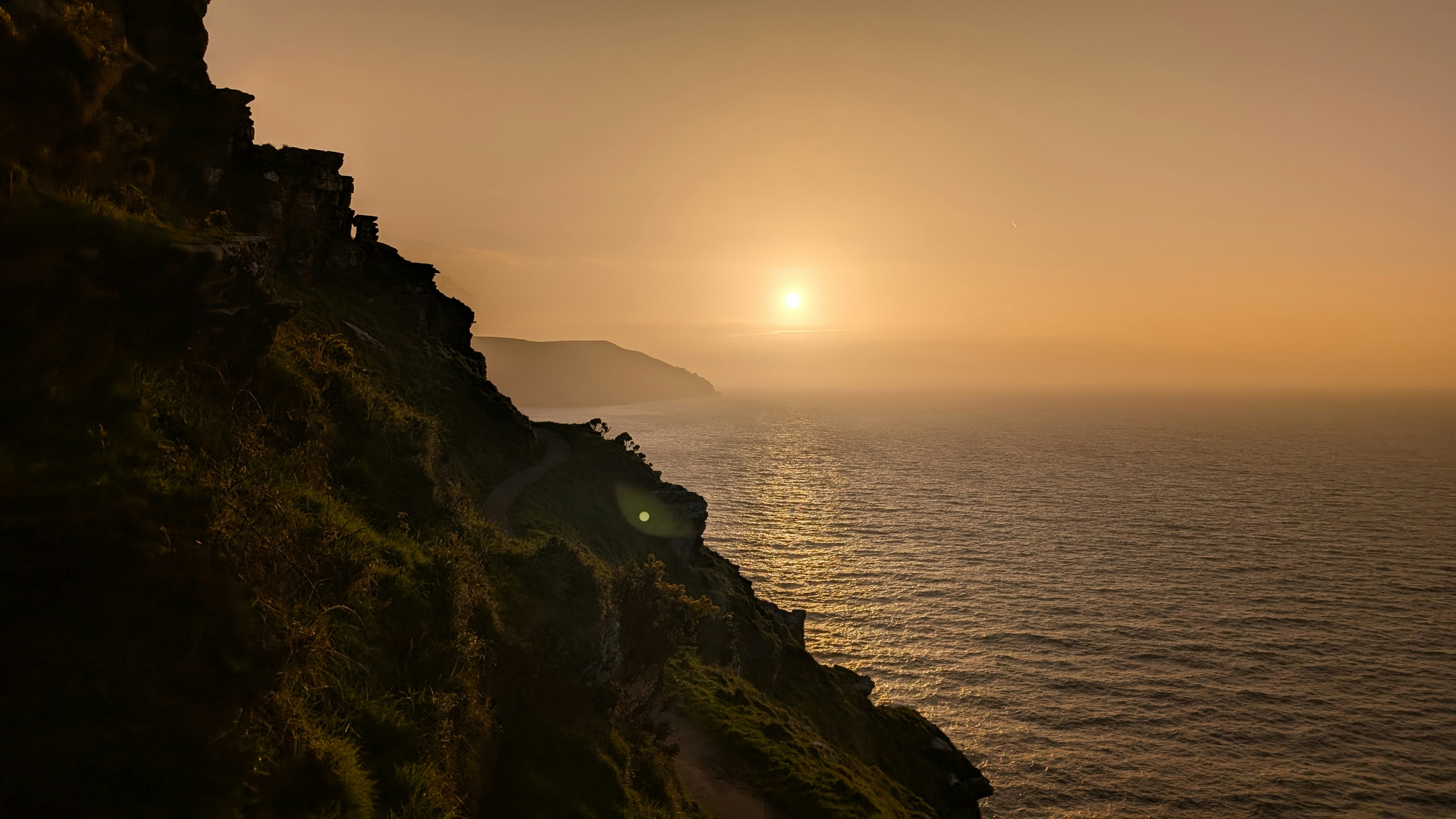 Sunlit Cliffs Over Quiet Seas