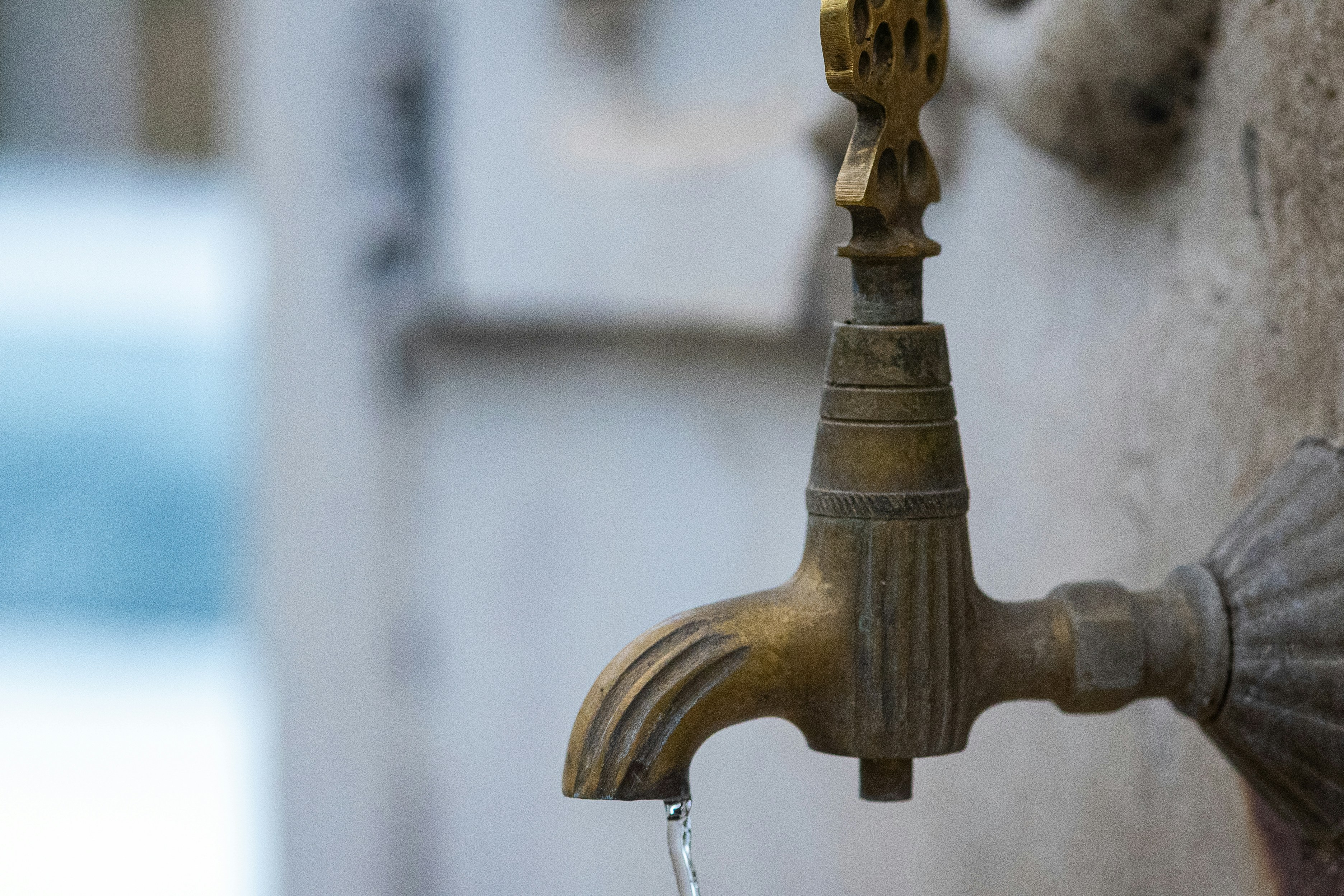 Old Water Tap against Blurred Marble Wall