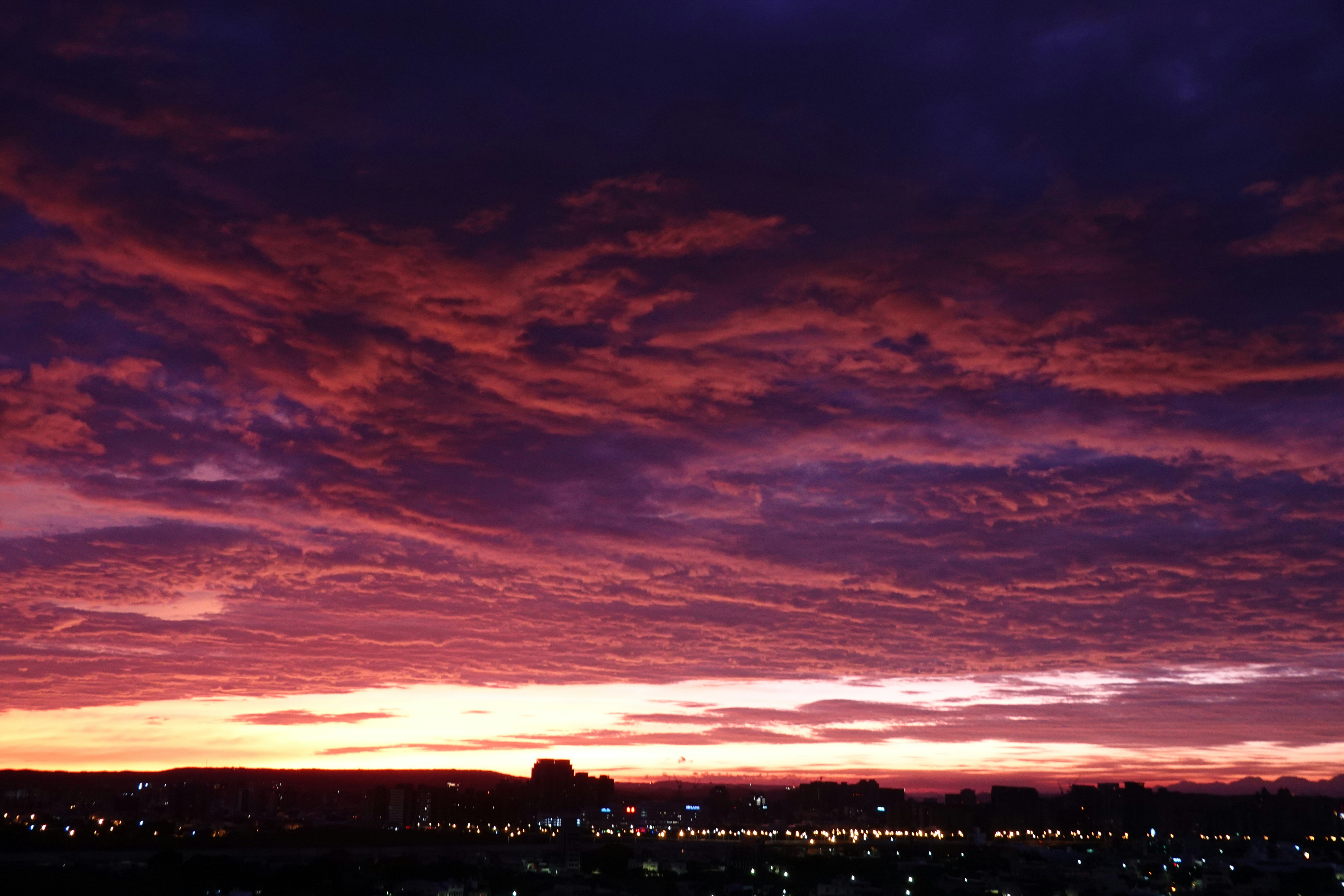 Dawn’s Quiet Edge: Silhouetted City against Fiery Horizon