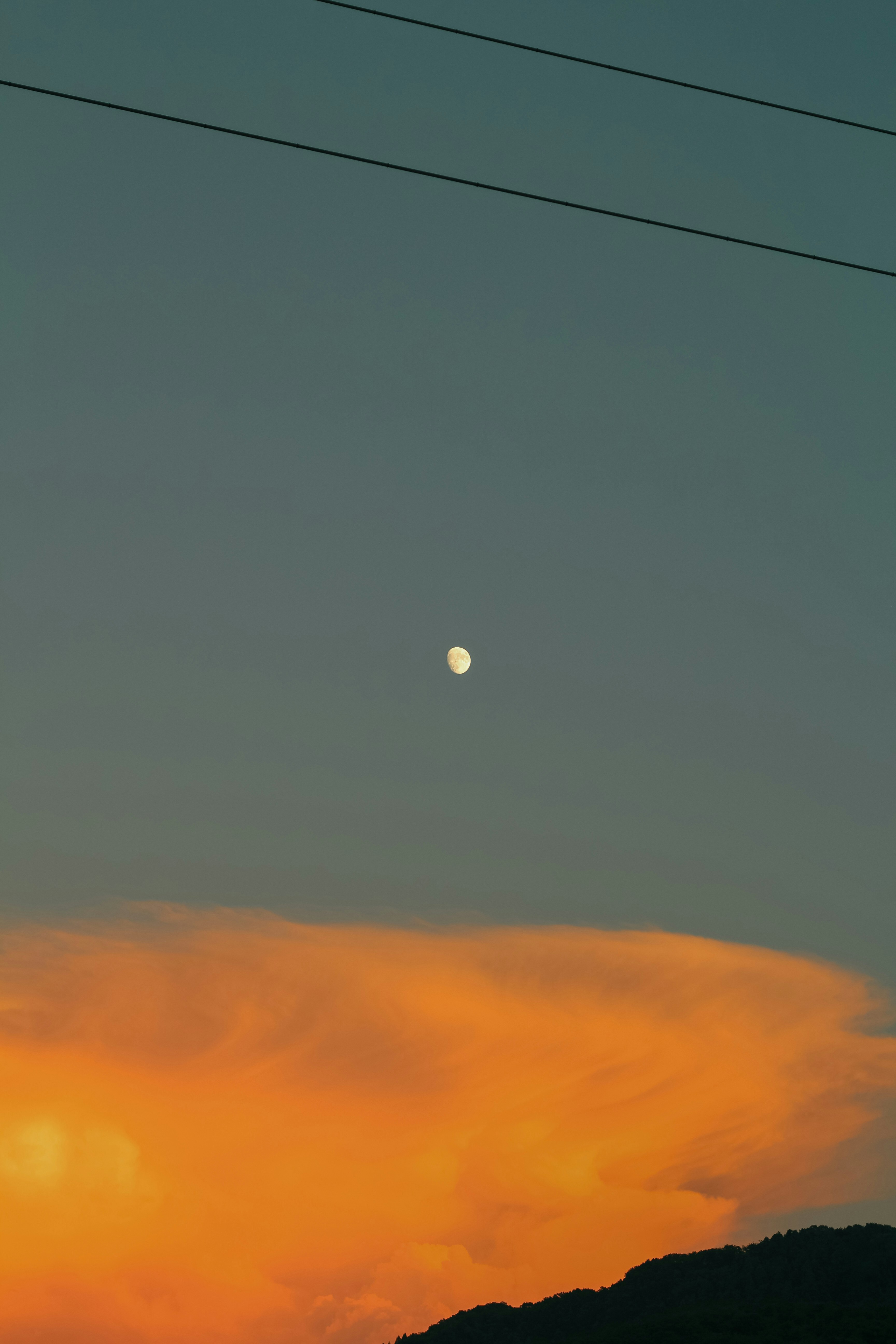 Moon Above the Quiet Horizon as Evening Cloud Glow Emerges