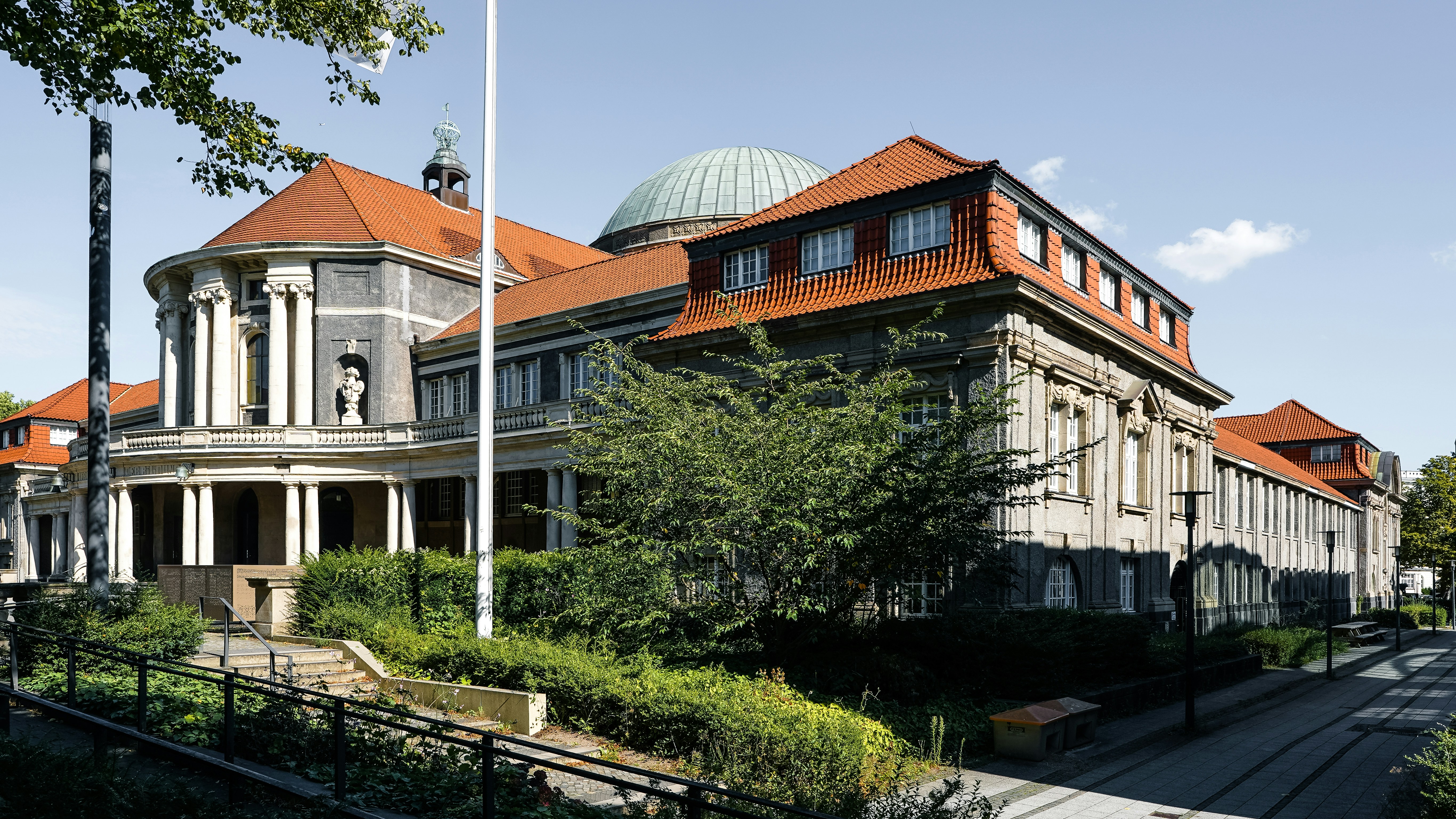 Domed Campus: A Historic Building with Red-Tiled Roofs and Verdant Forecourt