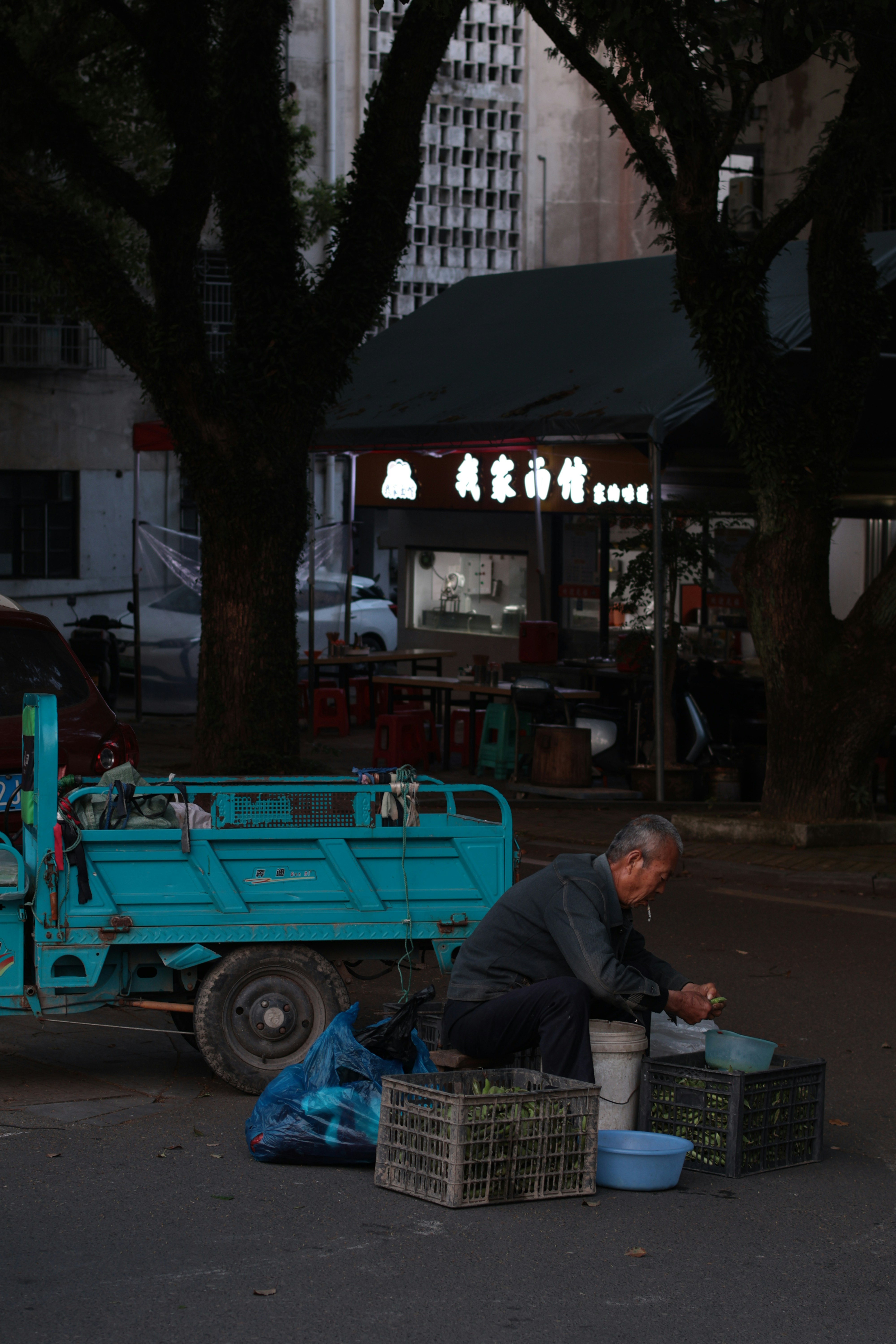 Lonely vendor by the urban edge, dusk light on a street stall