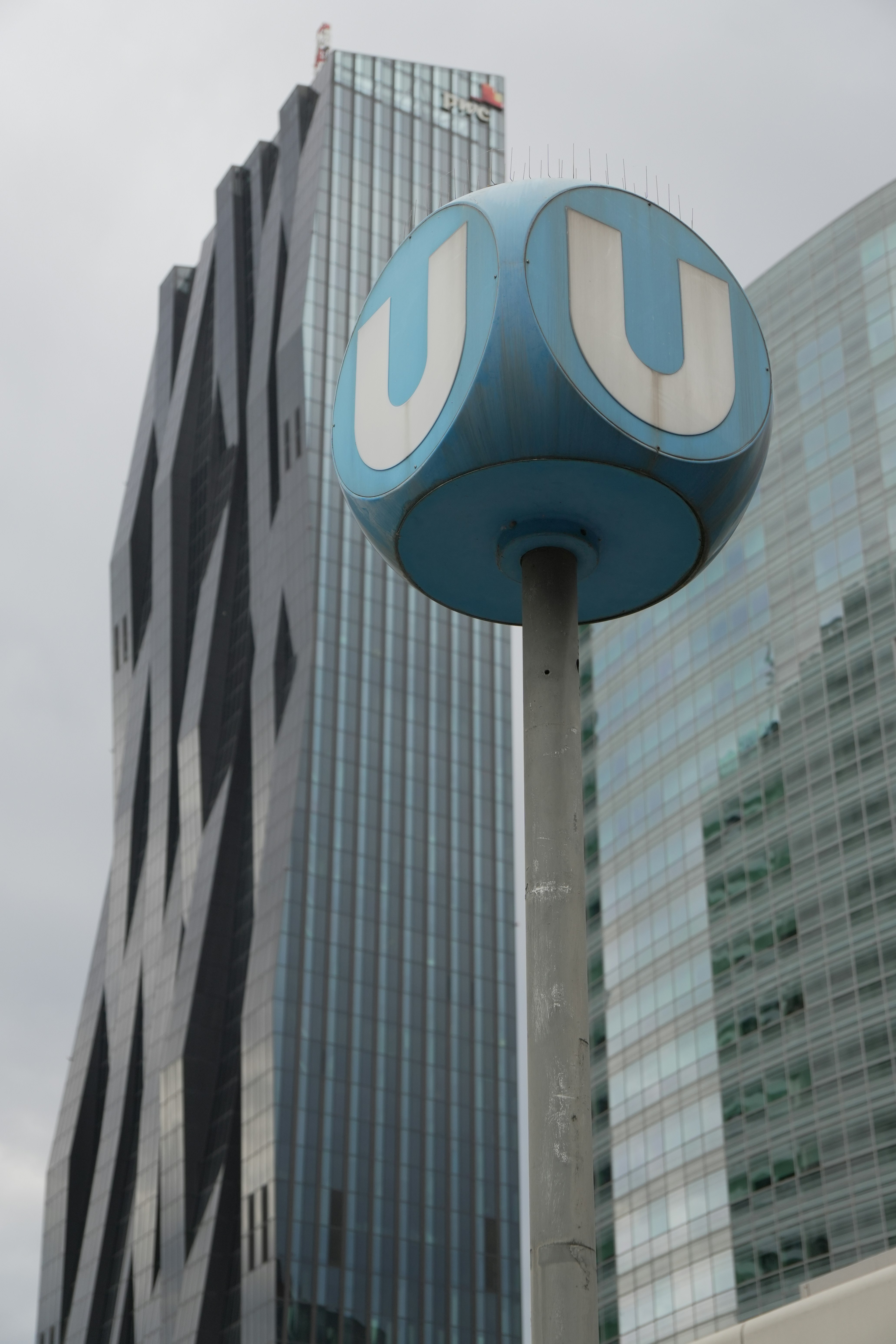 Urban Crest: The Blue U Sign Against Glass Skyscrapers