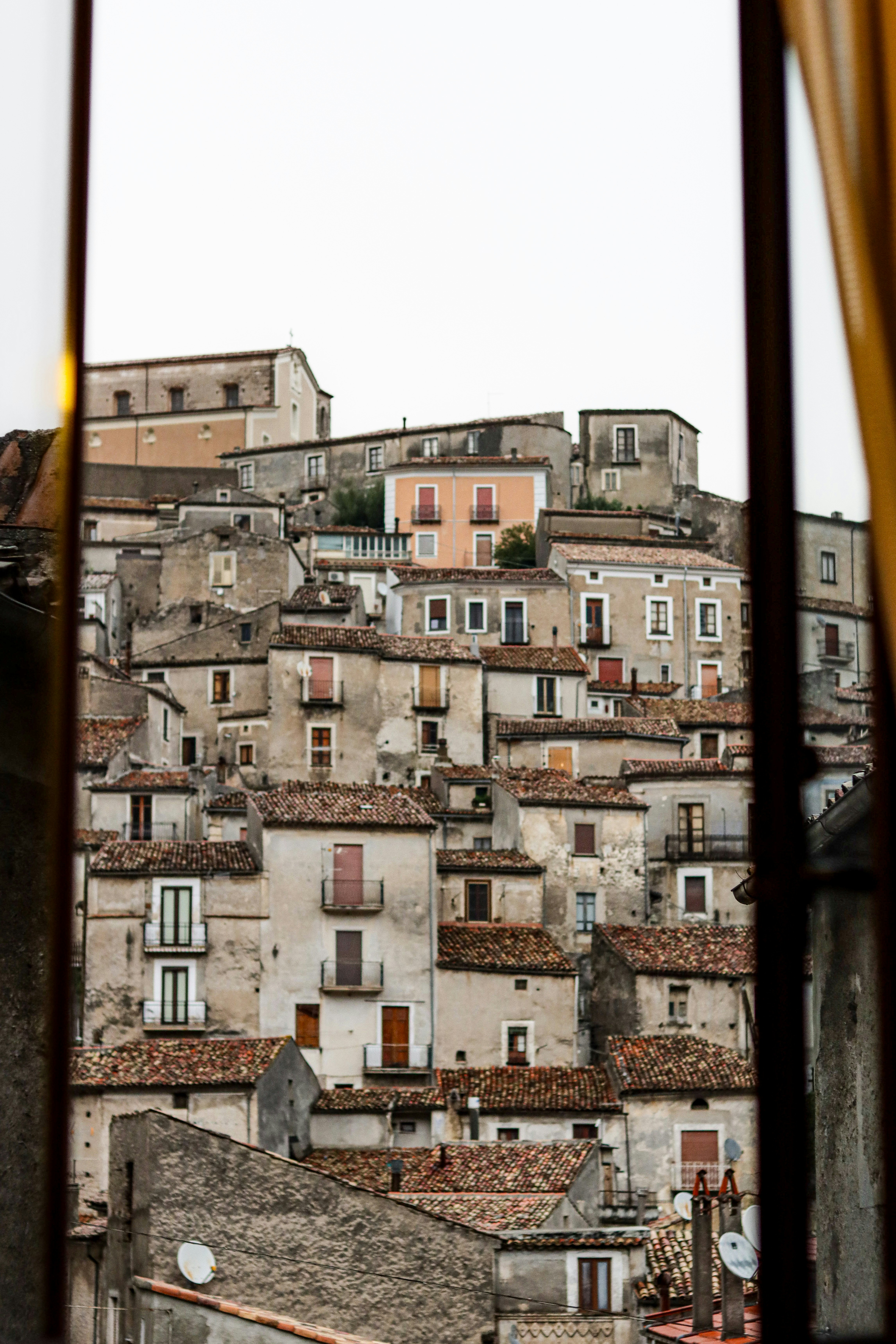 Colorful hillside dwellings framed by iron bars