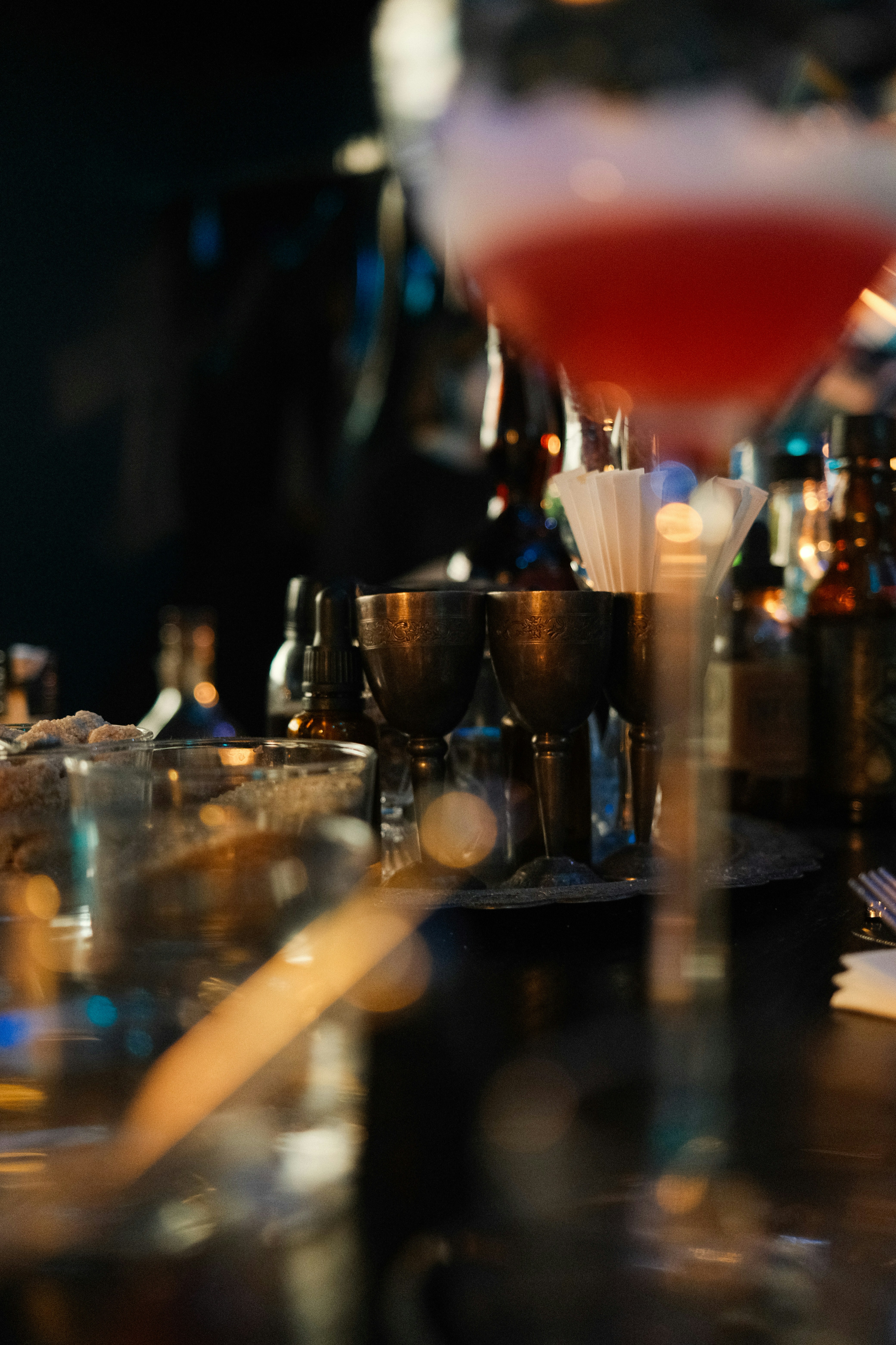 Blurred Rosé Over the Bar: Glassware in Soft Neon Glow