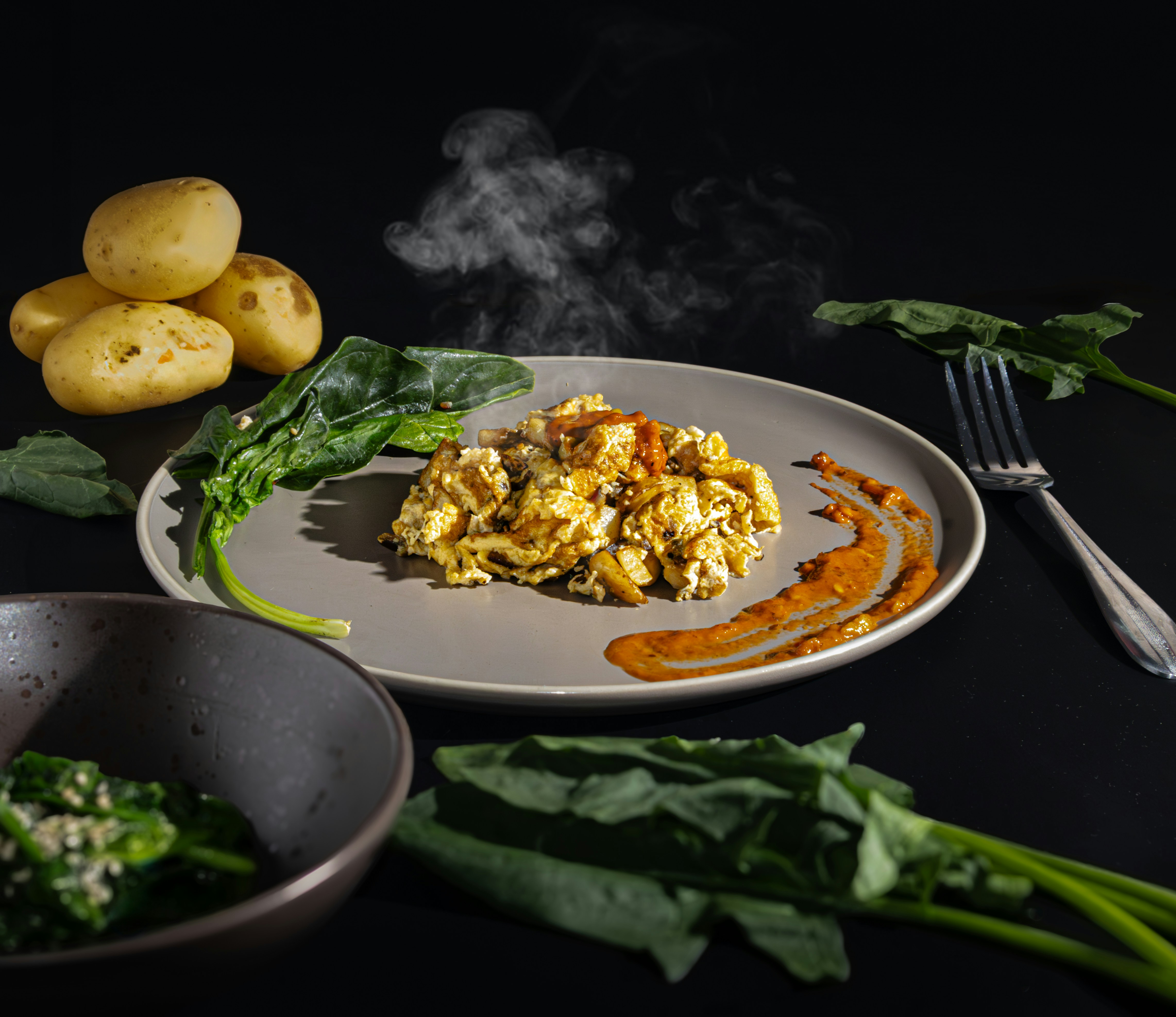 Steam-kissed plate: scrambled chicken with greens on a slate night