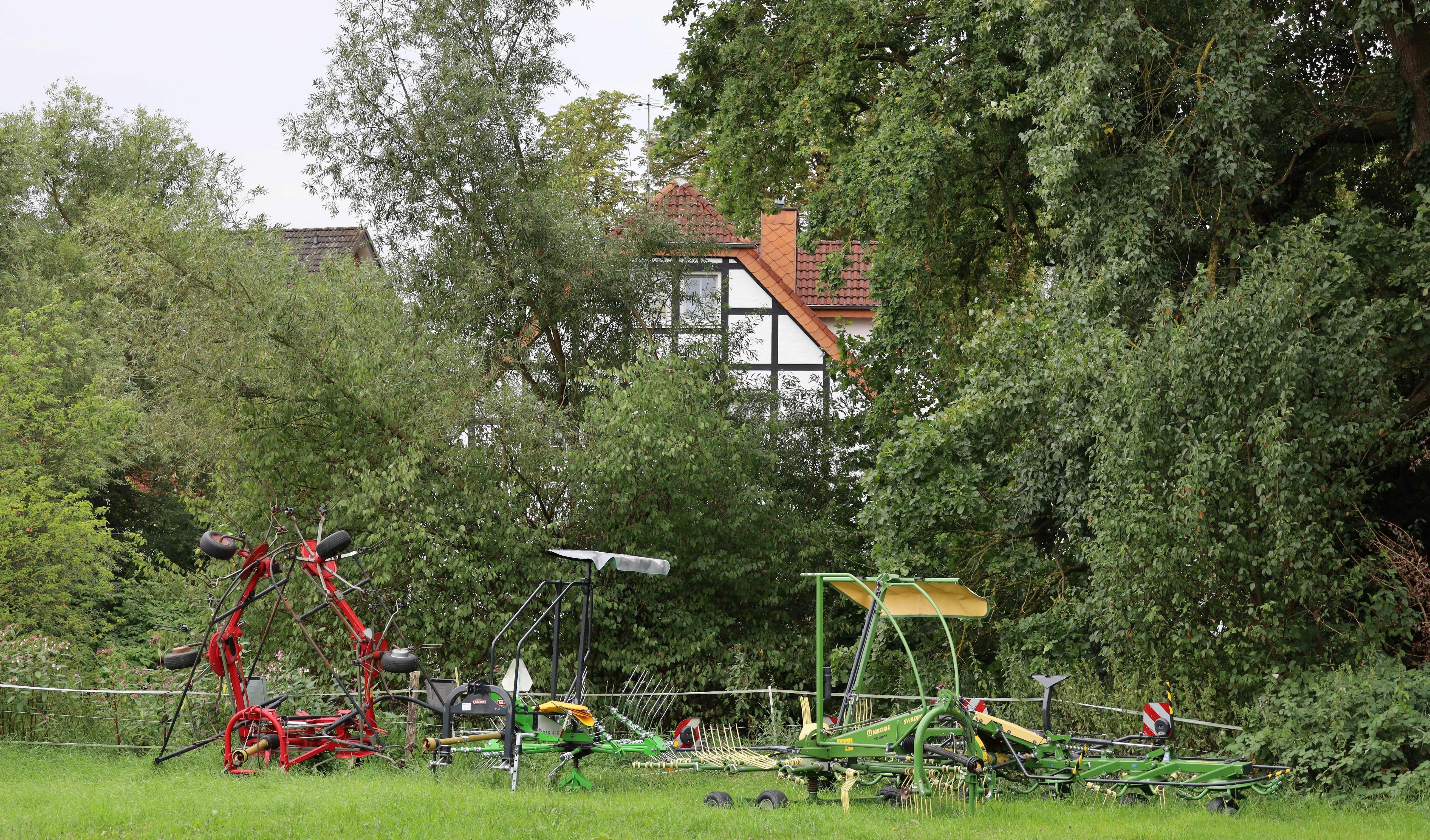 Red Farm Machinery Resting Beneath a Green Canopy