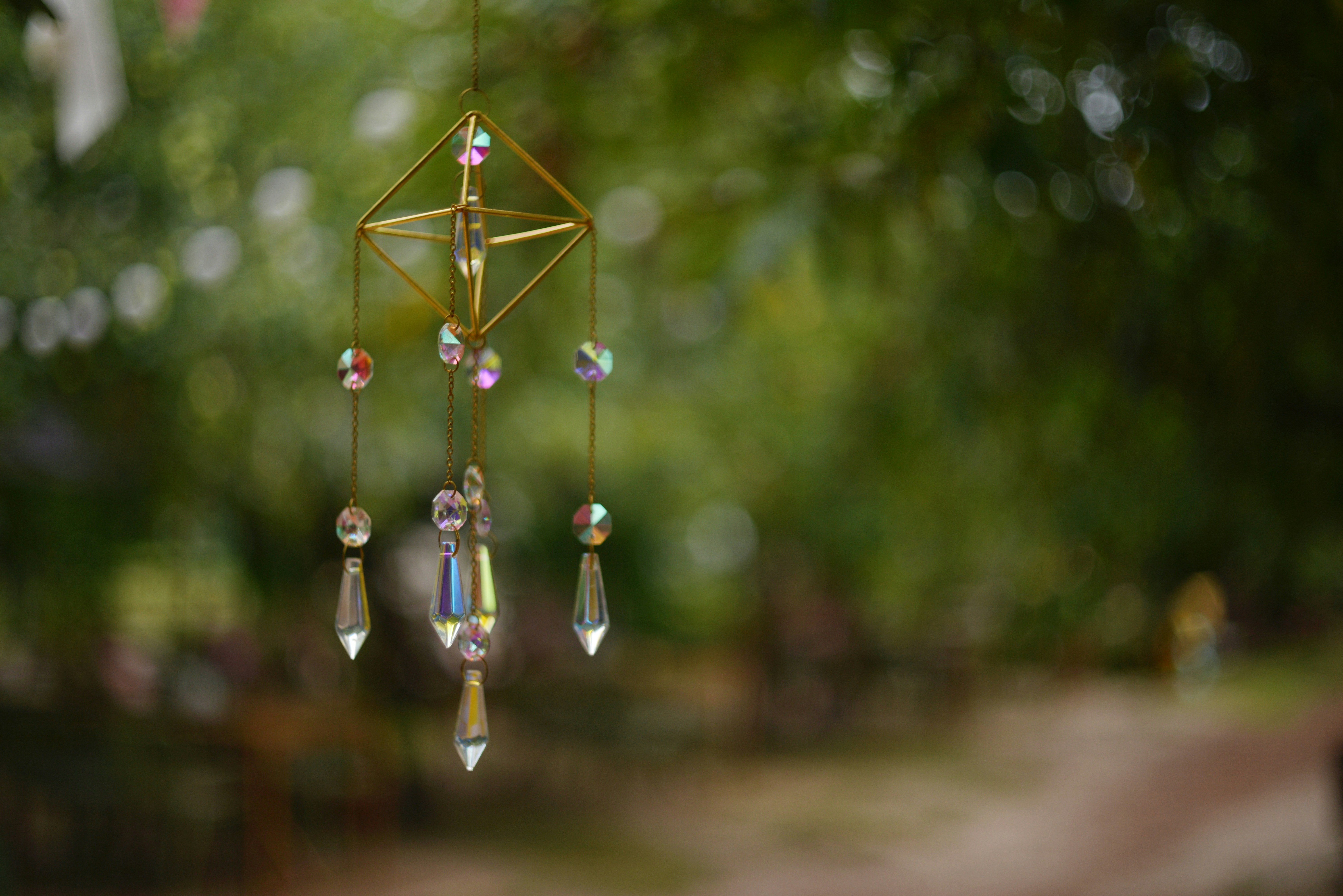 Crystal triangular charm in a sunlit garden wind