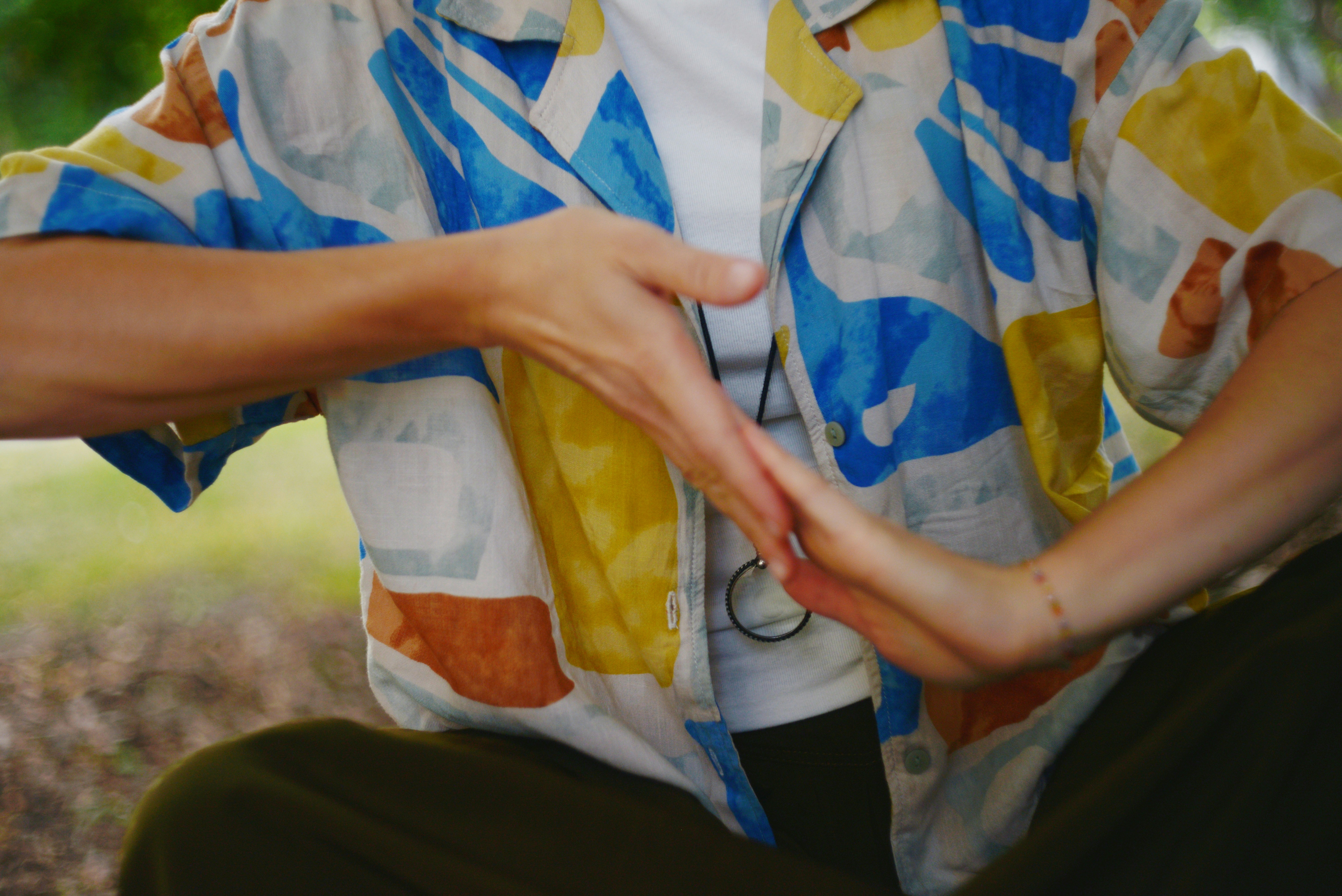 Hands in Motion: A Calm, Expressive Gesture in a Colorful Outdoor Ensemble