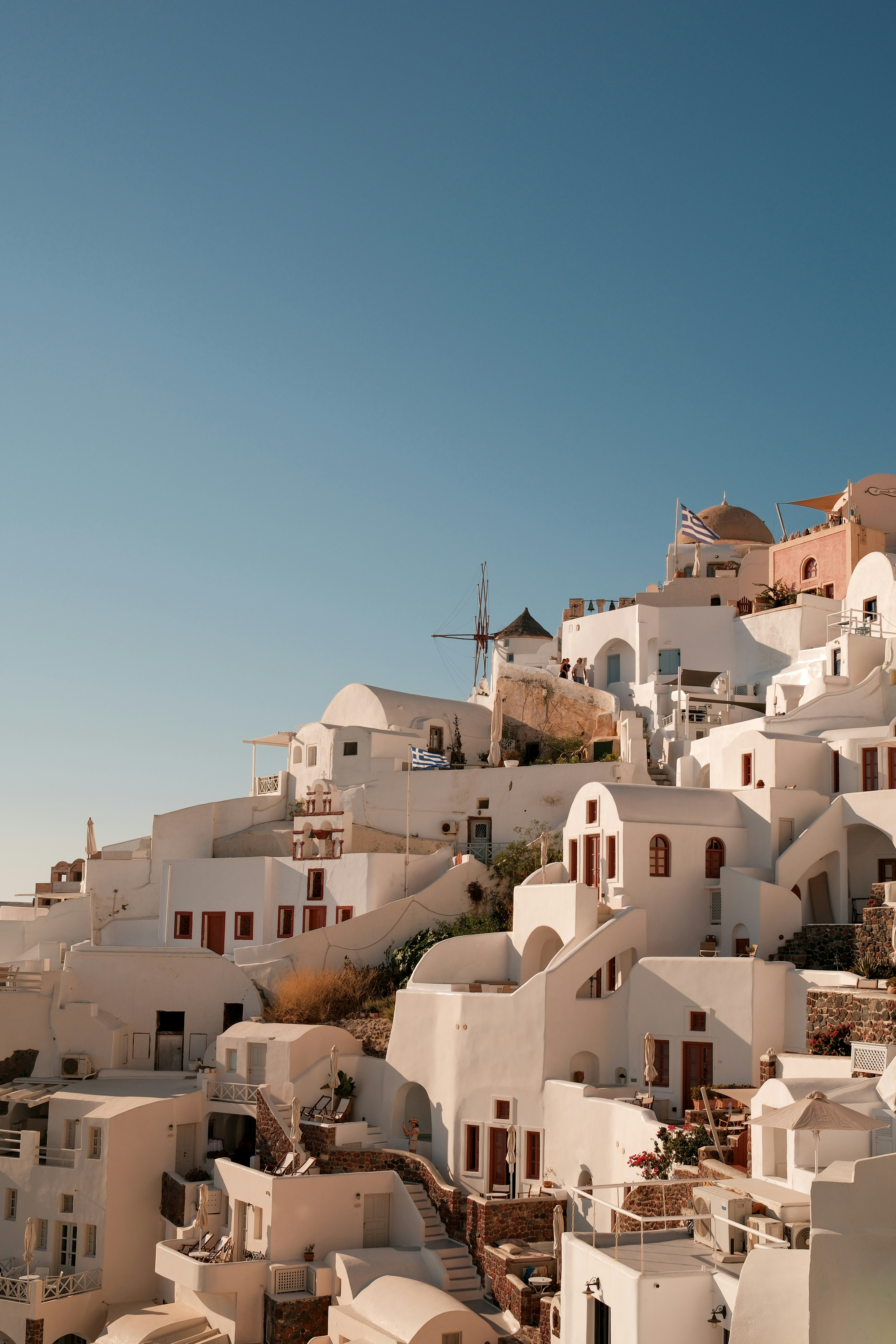 Whitewashed village stairway cascade under a clear Aegean sky