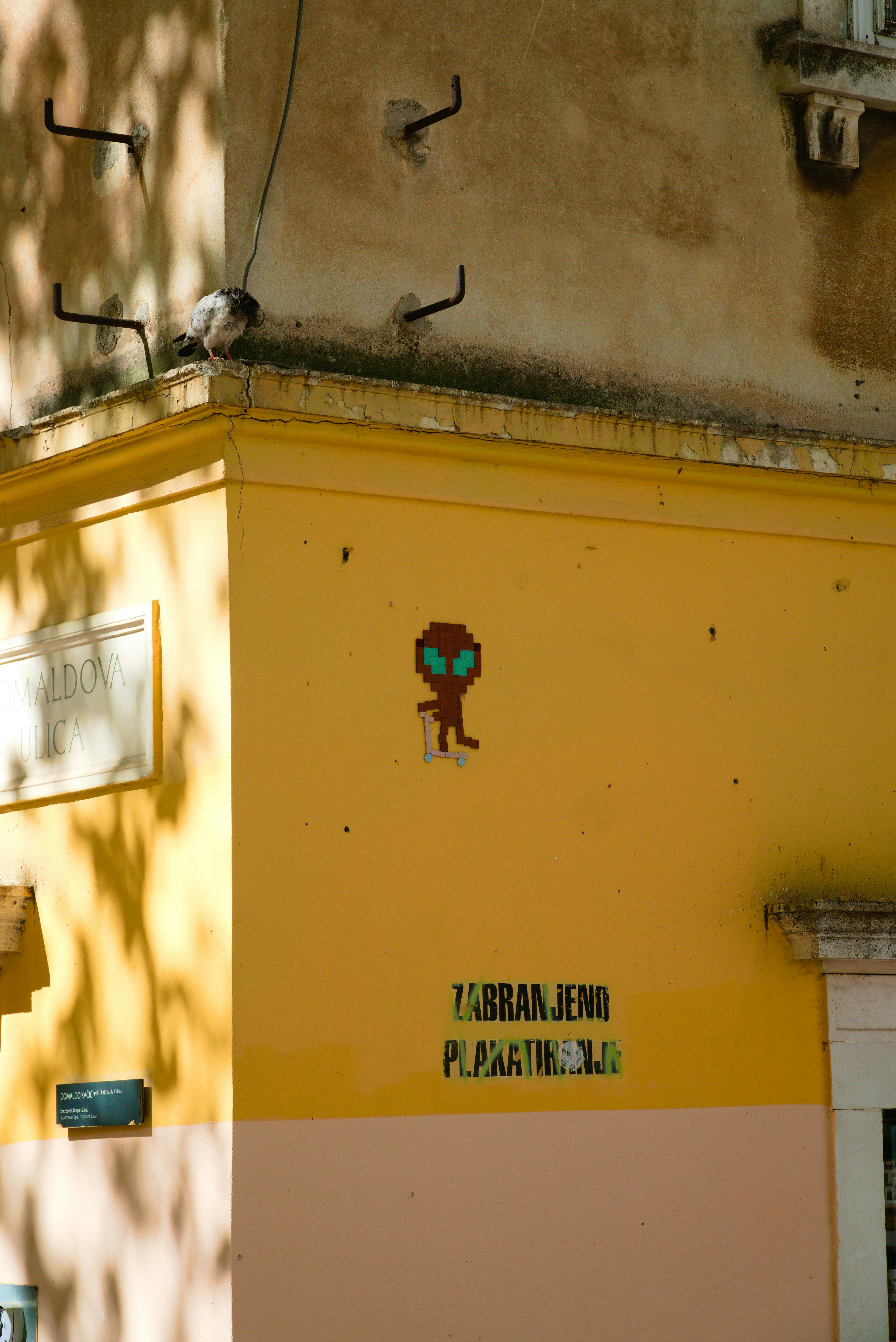 Yellow Corner: A Quiet Street Scene with Pixel Alien