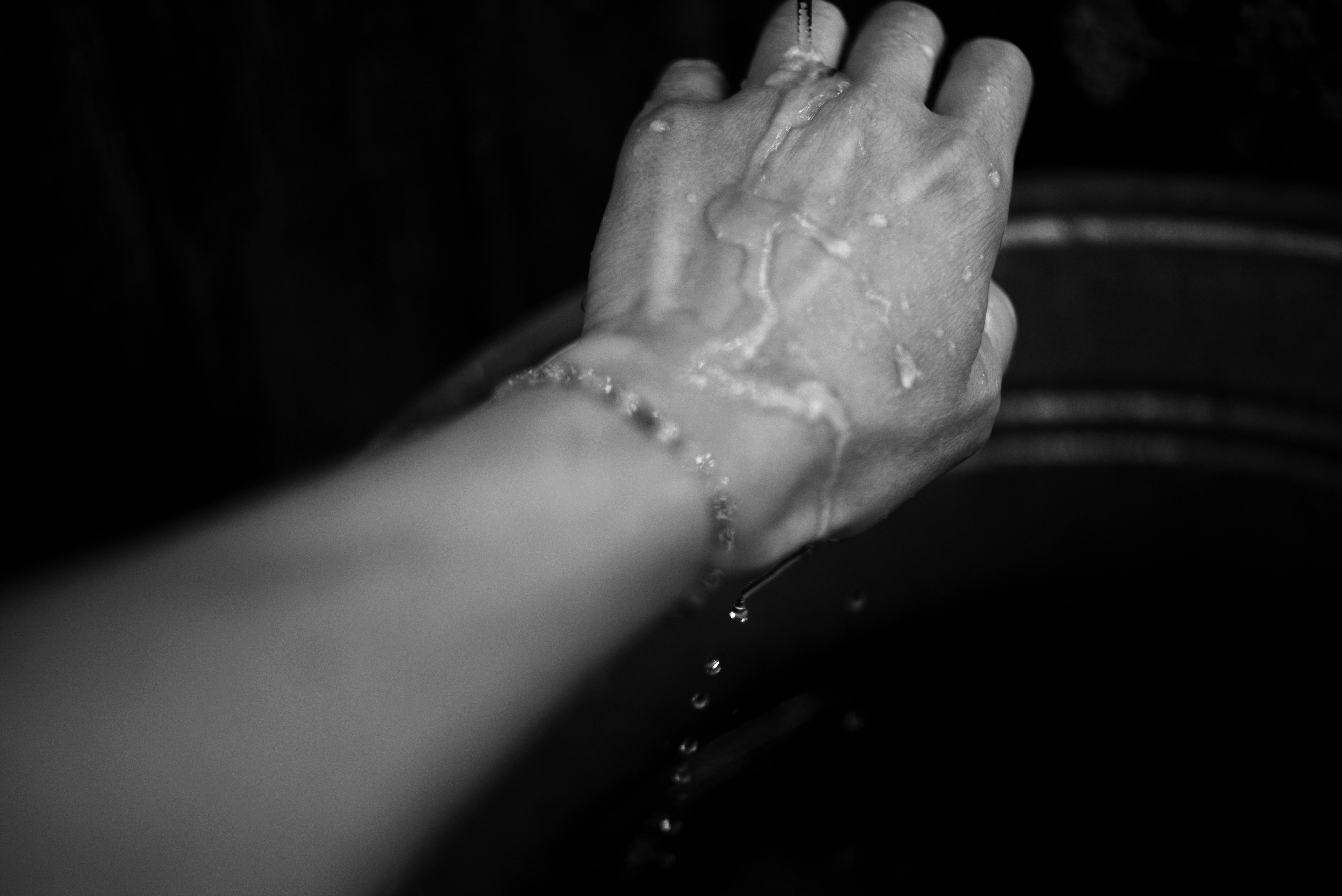 Light at the Tap: A Hand Meeting a Quiet Stream