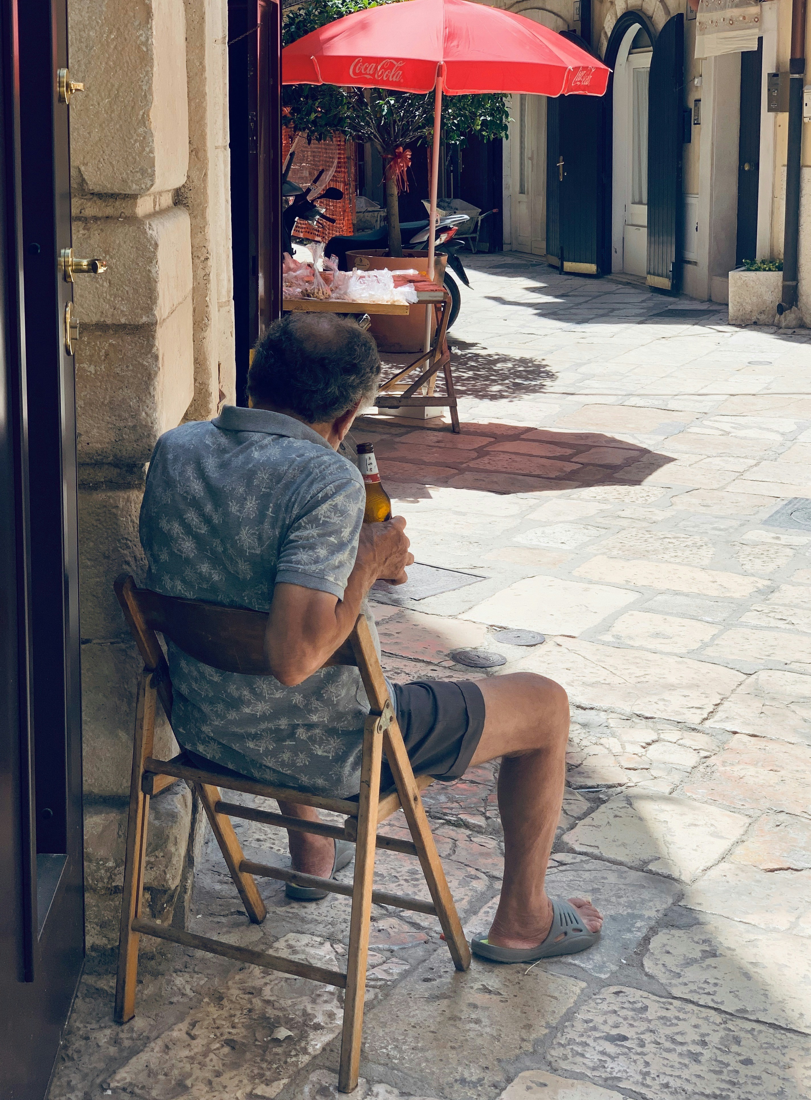Relaxed Stranger under Red Shade in Sunny Calle