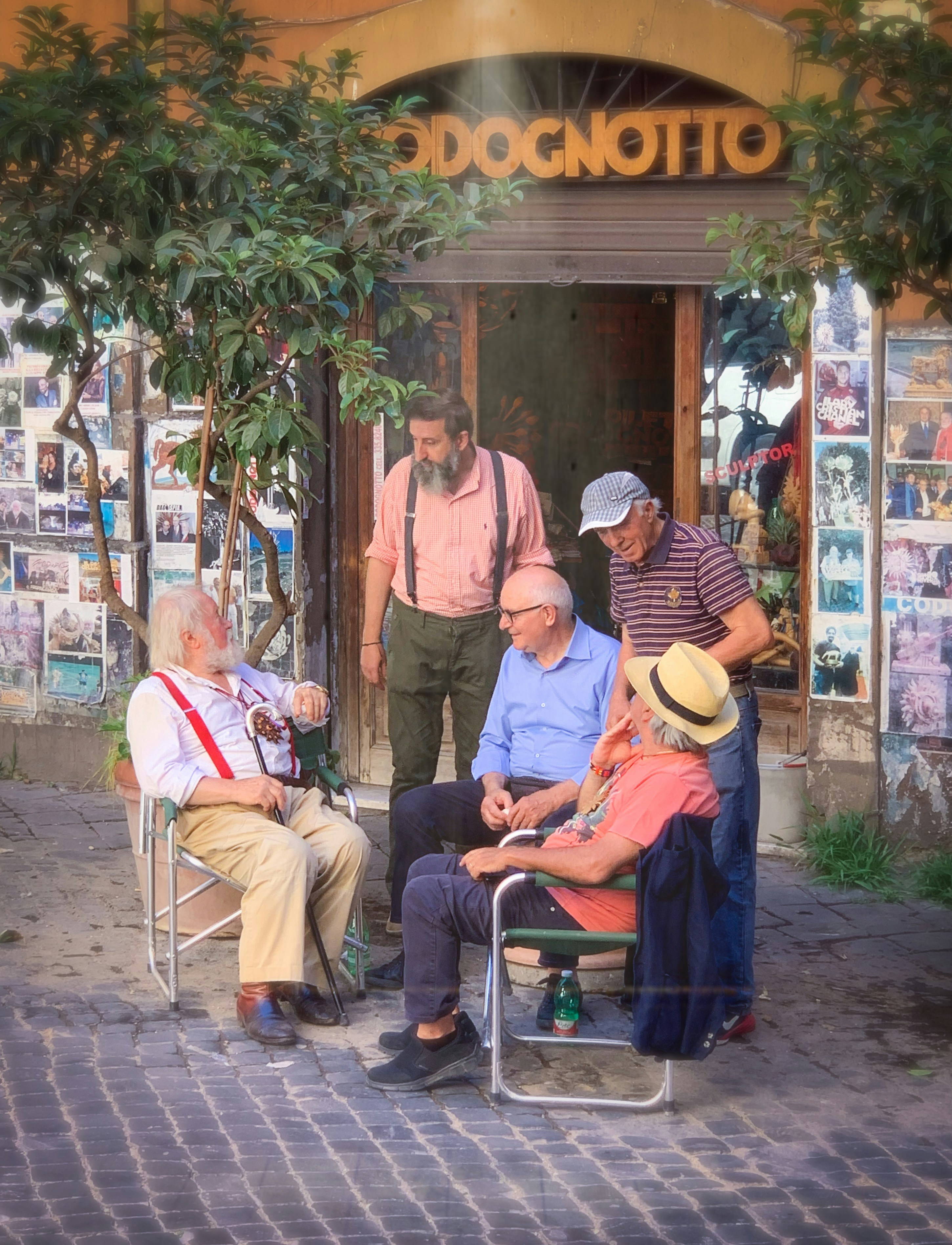 A Circle of Gentlemen: Conversation by the Shopfront Terrace