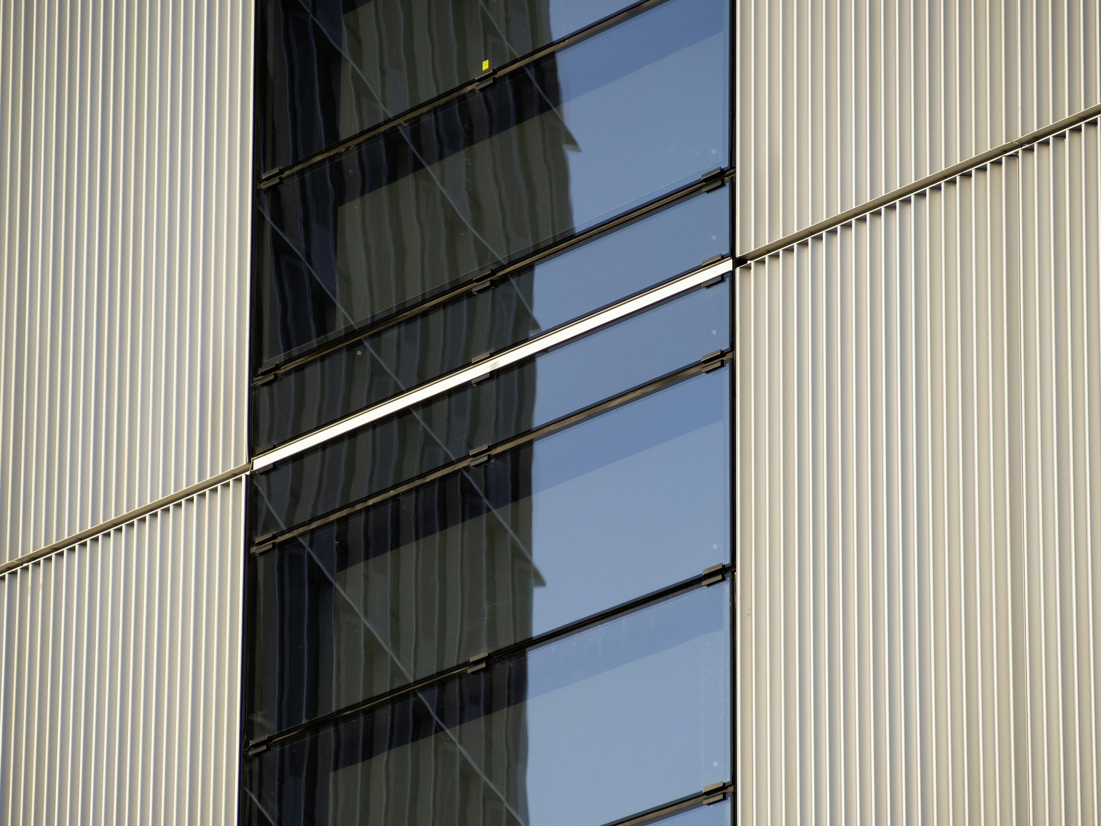 Glass and ribbed metal: urban light on a modern façade