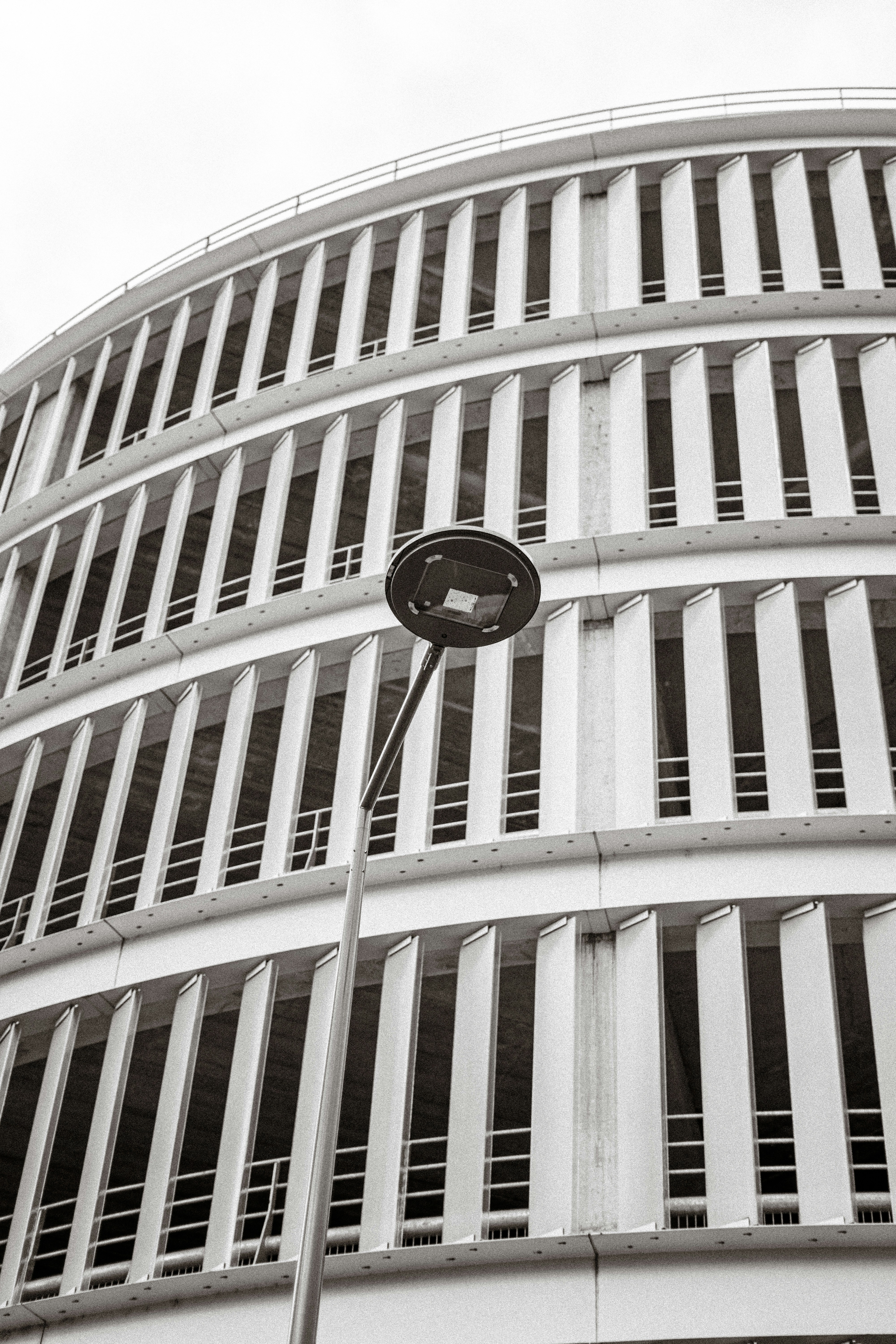 Curved façade and streetlamp: rhythm of vertical slats