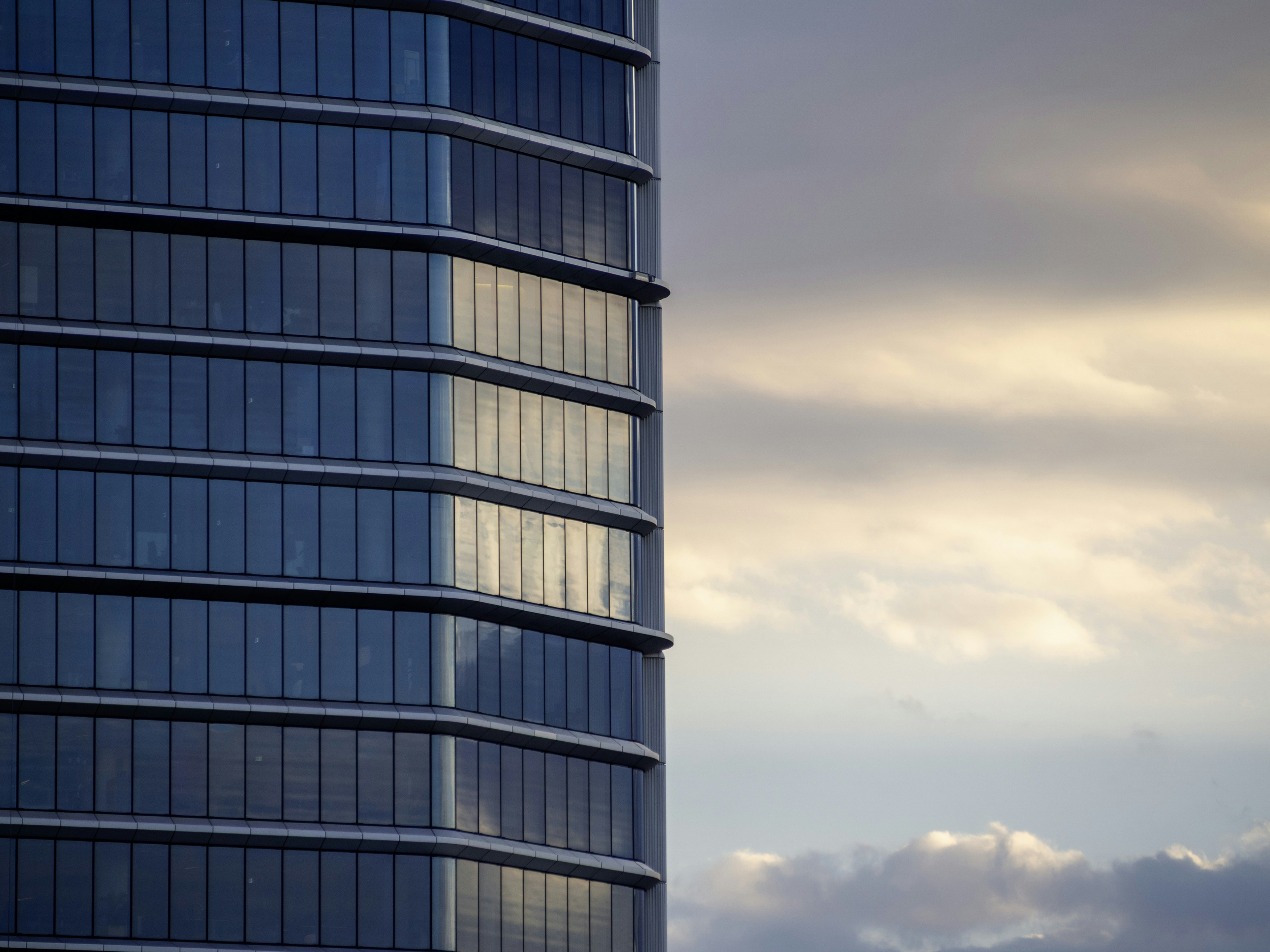 Reflective Facade at Dusk: A Vertical Mosaic of Glass and Light