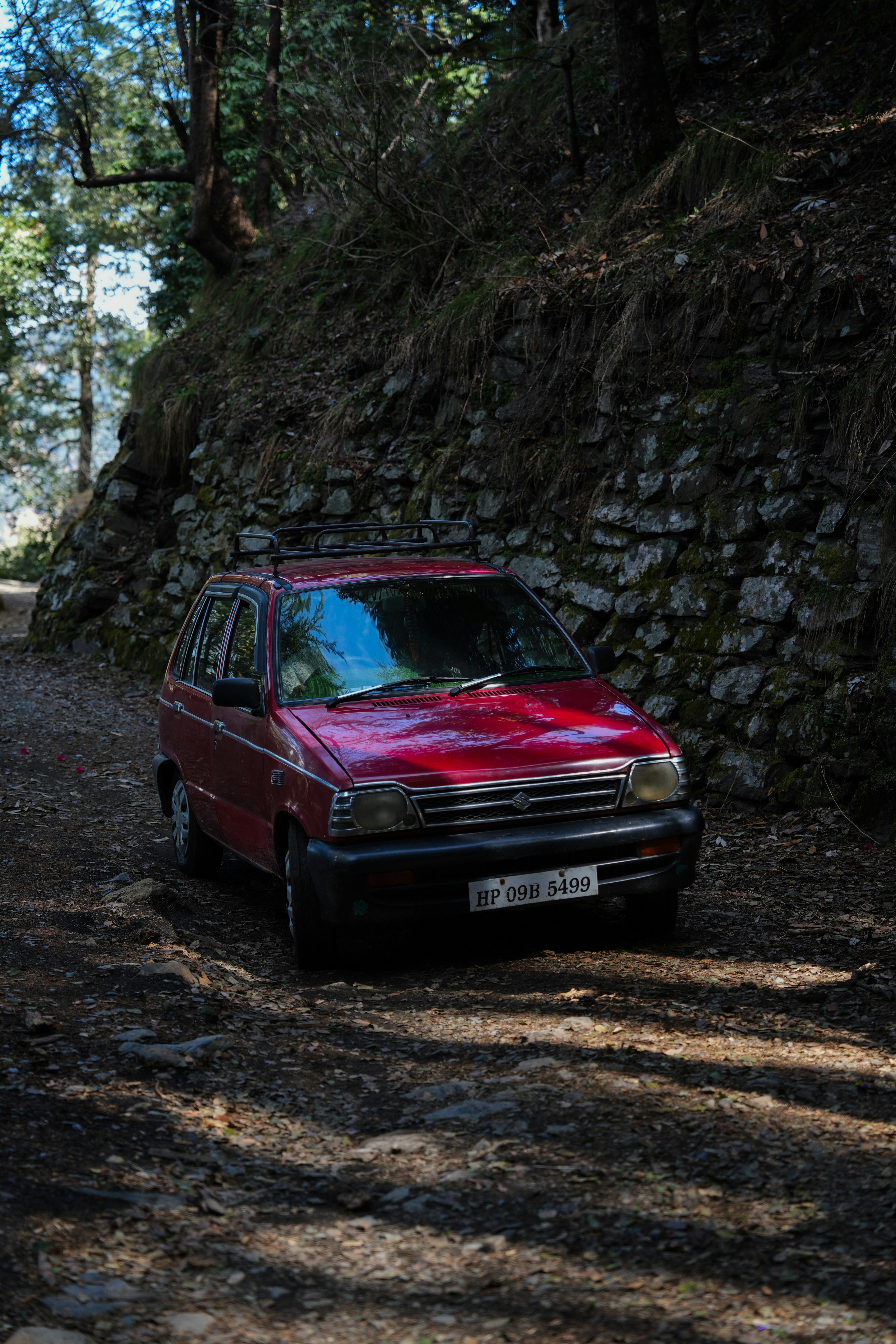Red Gate: A Rugged Clunker Resting Along a Forested Cliff Road
