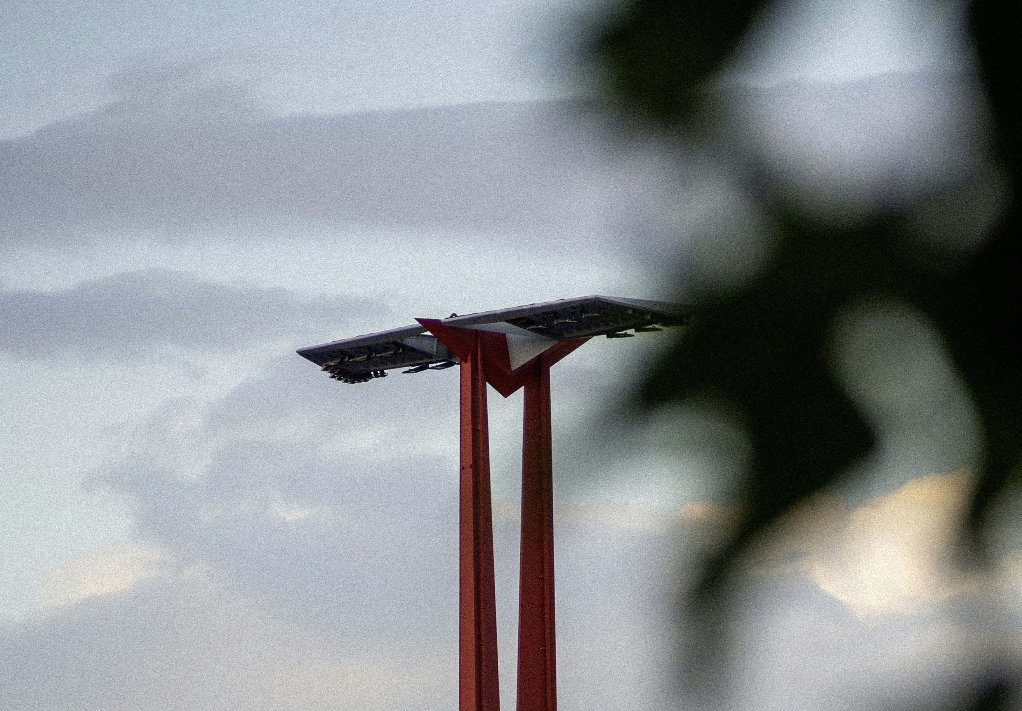 Red Tower Spotlight: A Minimalist Sky-Frame Pierced by Bright Steel