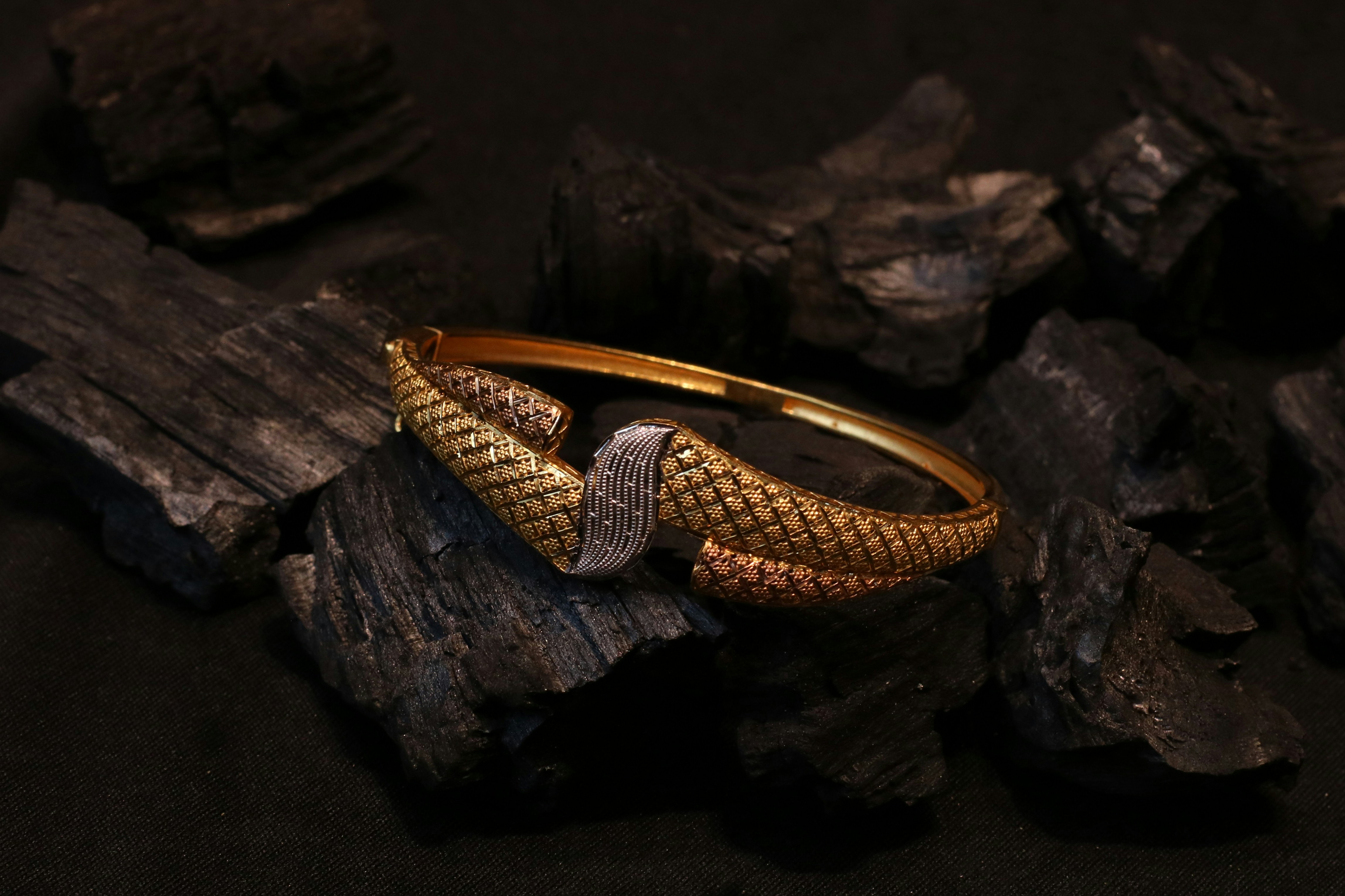 Golden Knot: A Ringed Glimmer Nestled in Ash and Coal