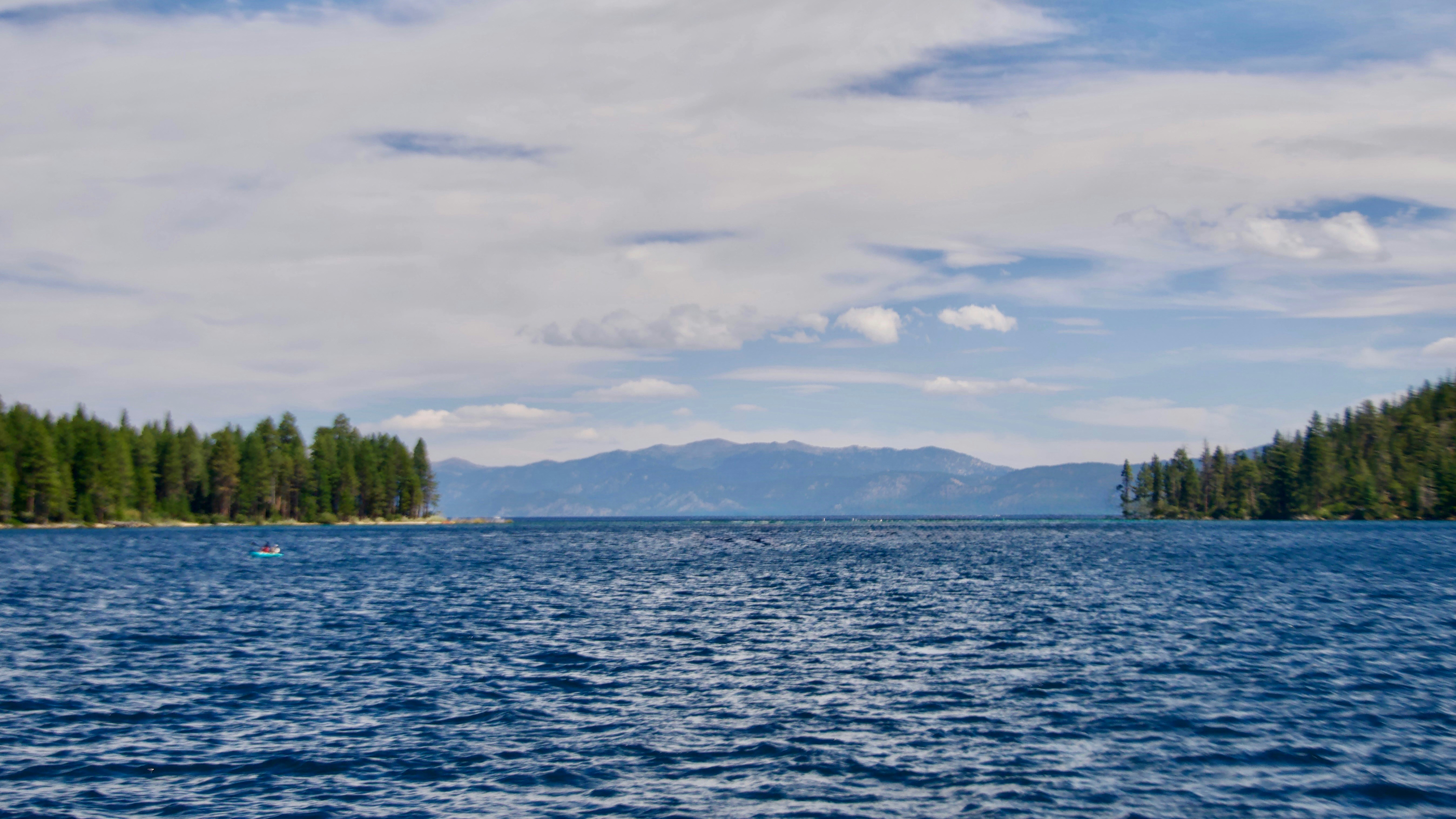 Midday Calm: A Wide-Vision Lake Between Forested Ridges