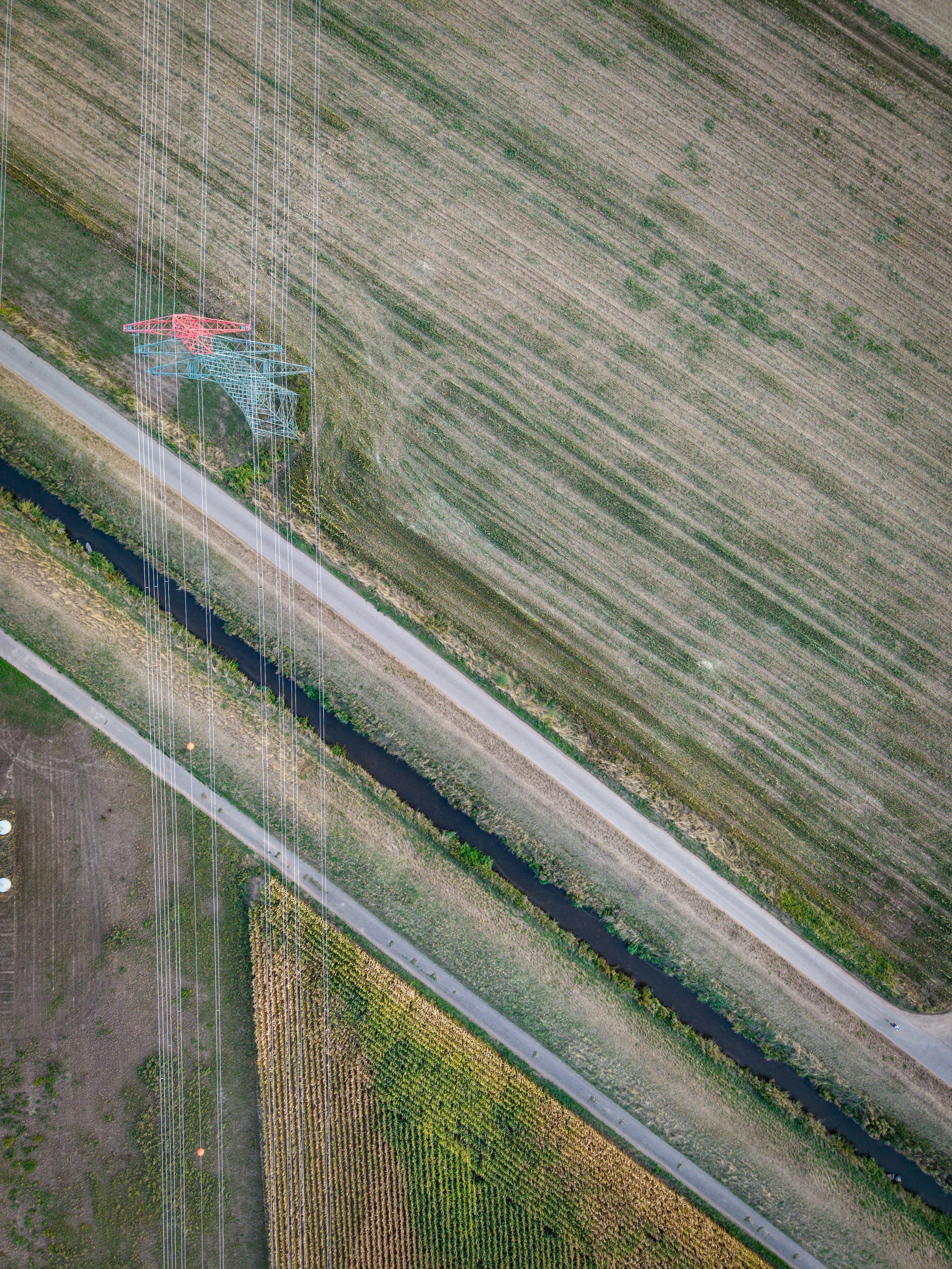 Aerial Corridor: Field Lines and Power Grid Stretch Across a Quiet Landscape