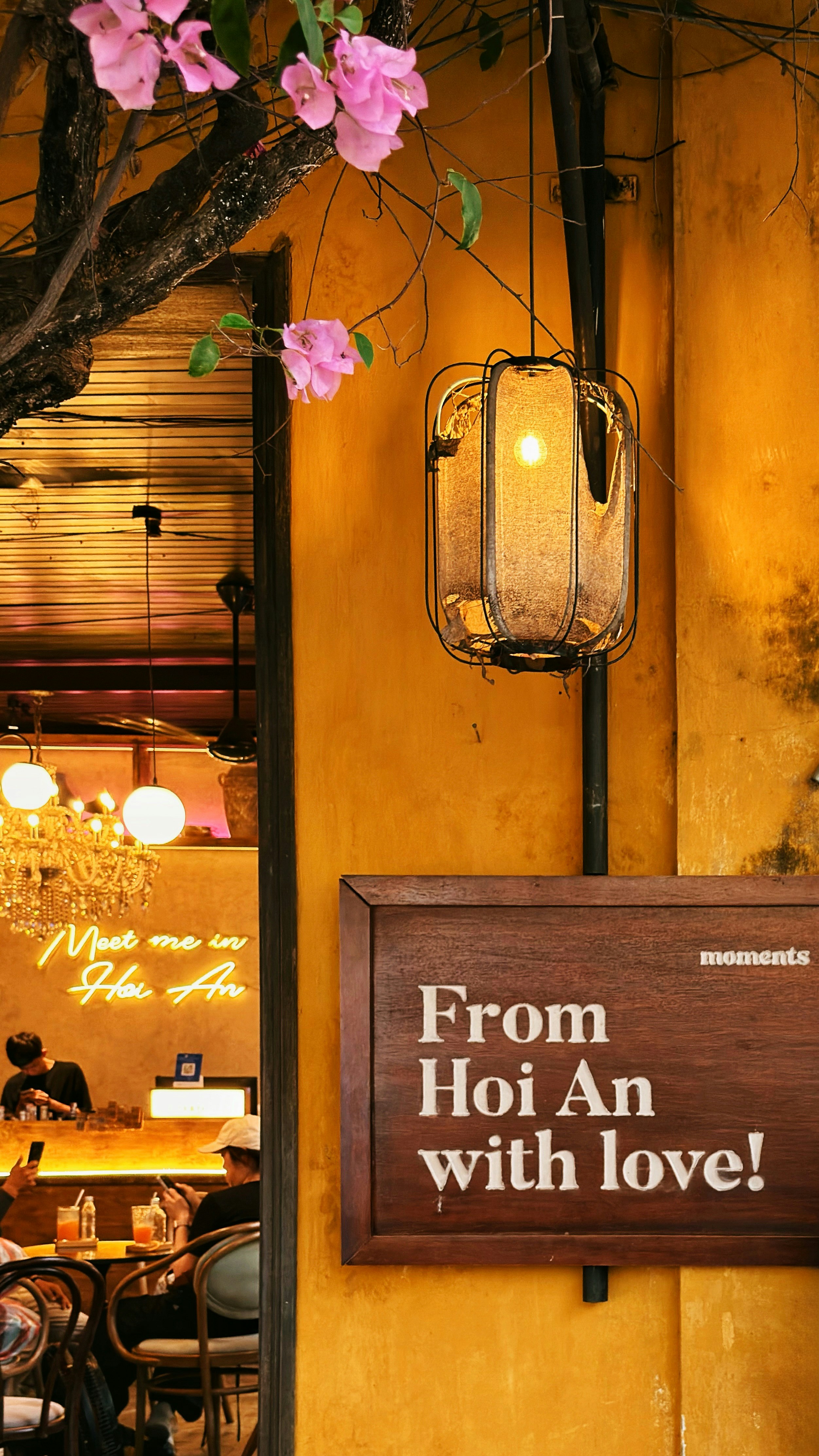 Warm Lanterns and Welcoming Signage at a Sunlit Café
