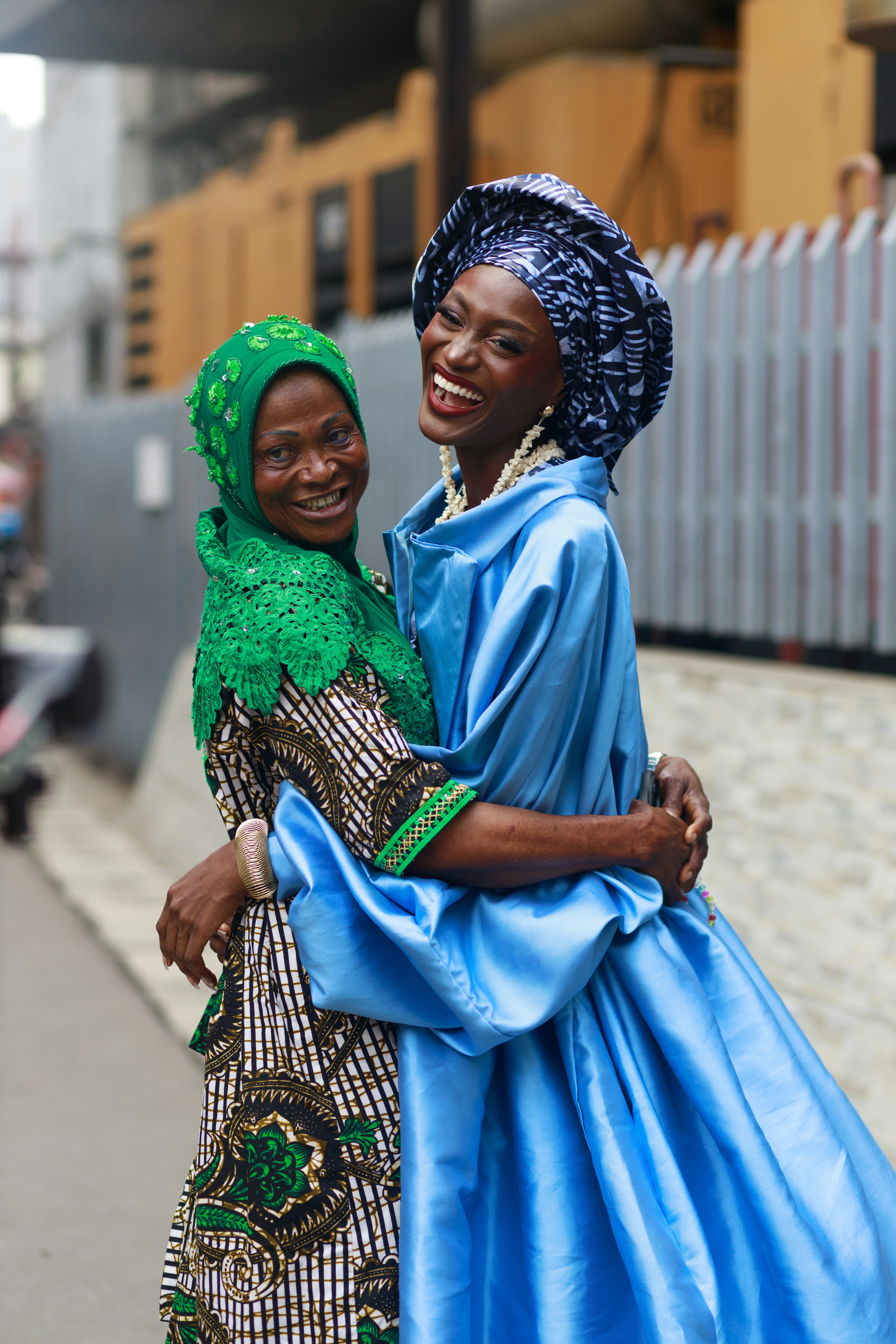 Joyful Embrace Between Two Queens in Colorful Attire
