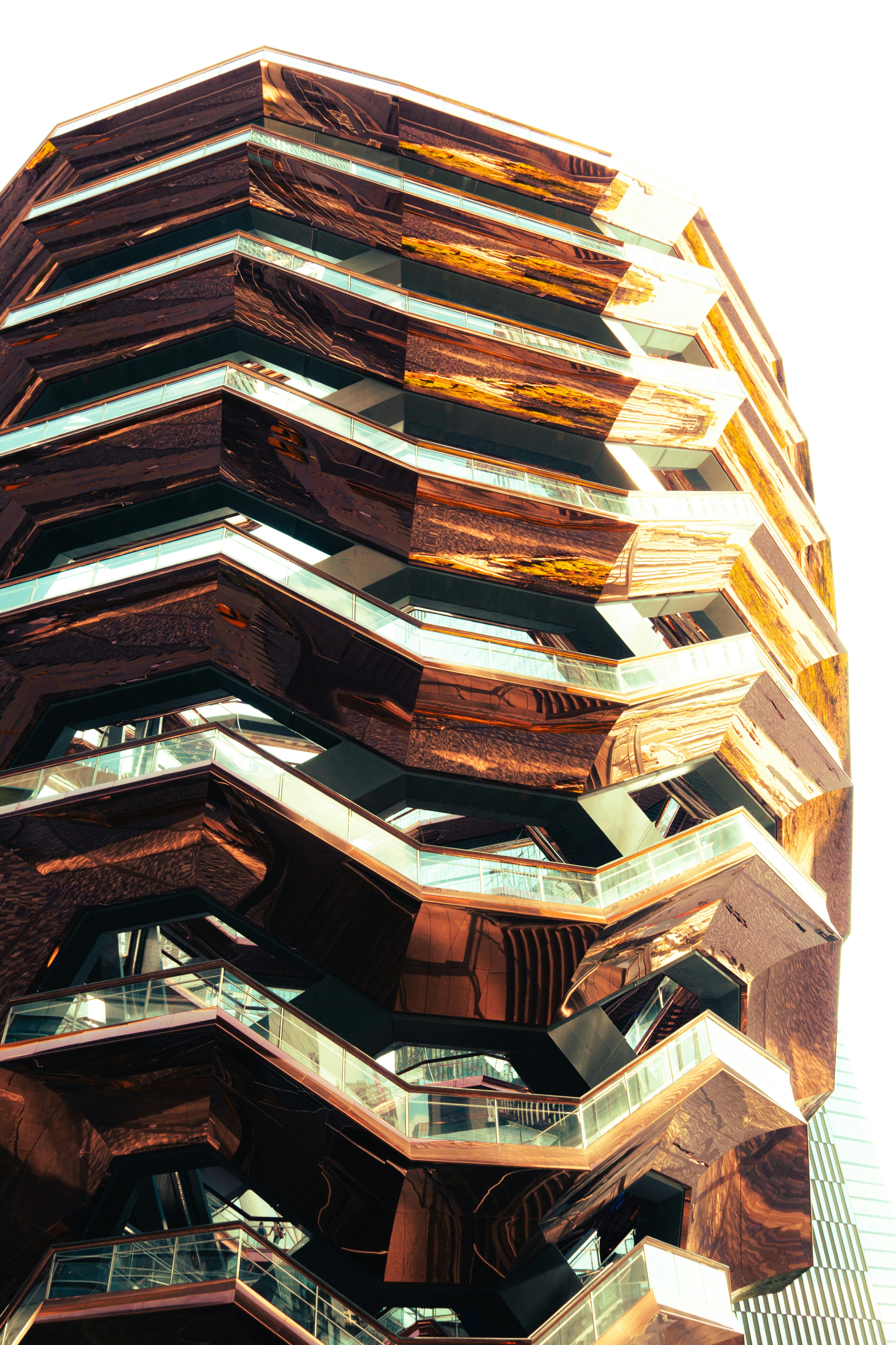 Kinetic Facade: Staggered Glass Ribbons on a Burnished Tower