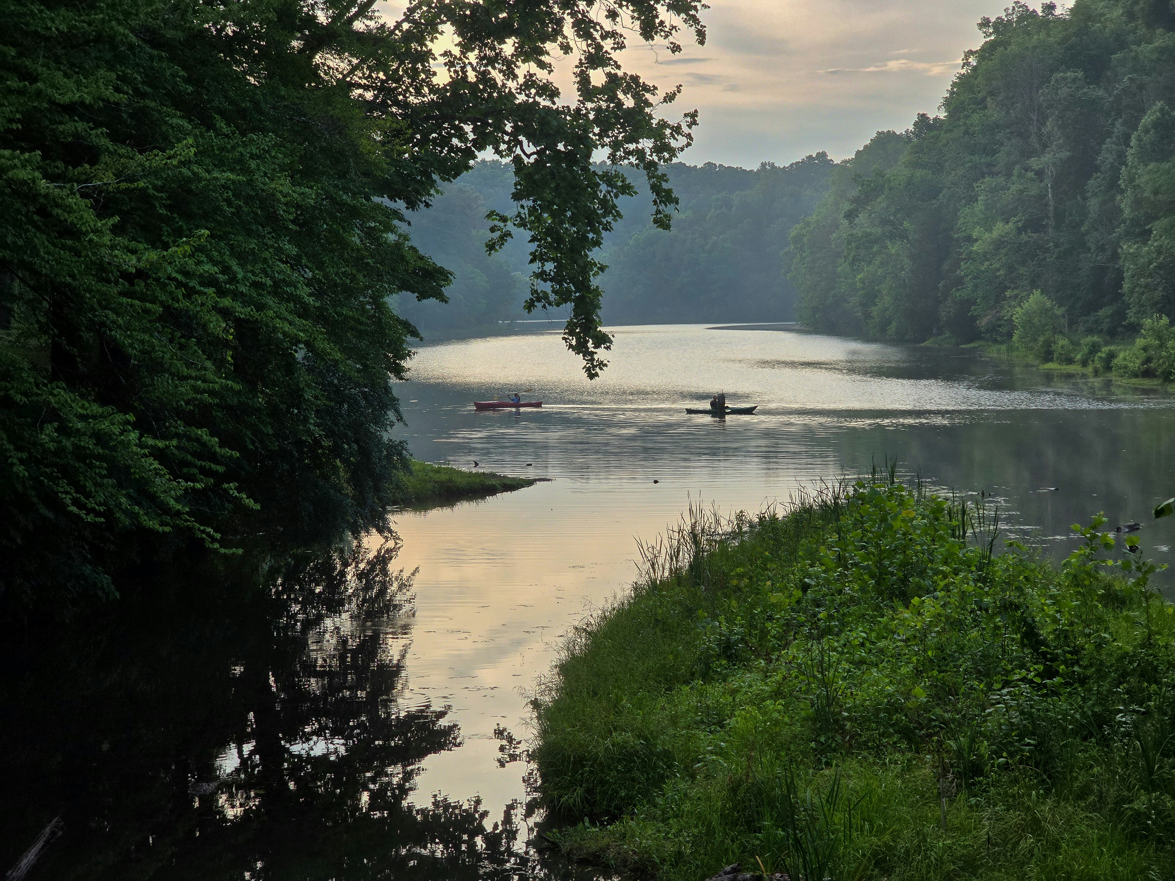 Quiet Bend: Two kayaks on a Dusk-Warmed River