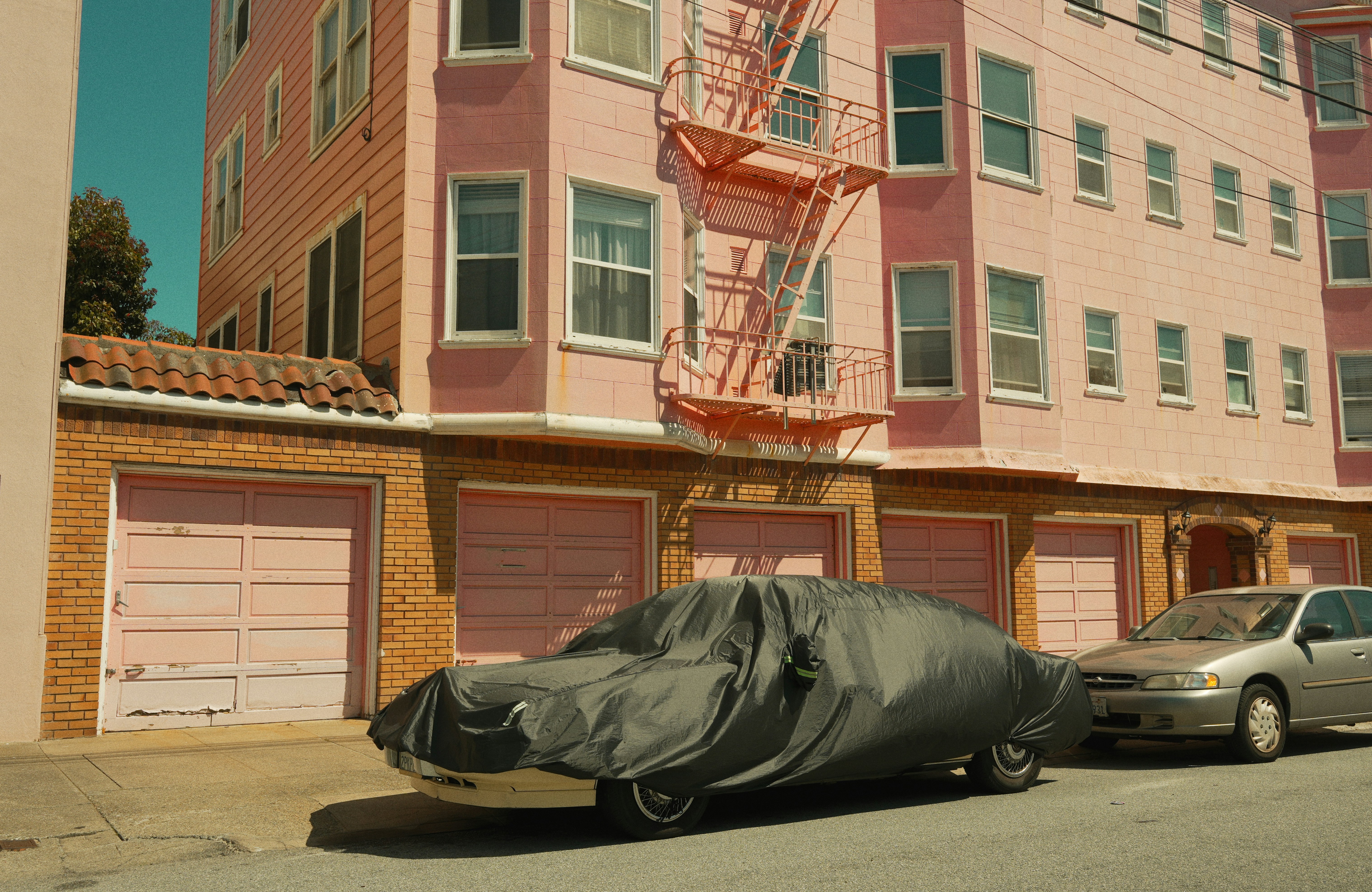 Hidden Marvel in Plain Sight: The Covered Car under the Pink Apartment Complex