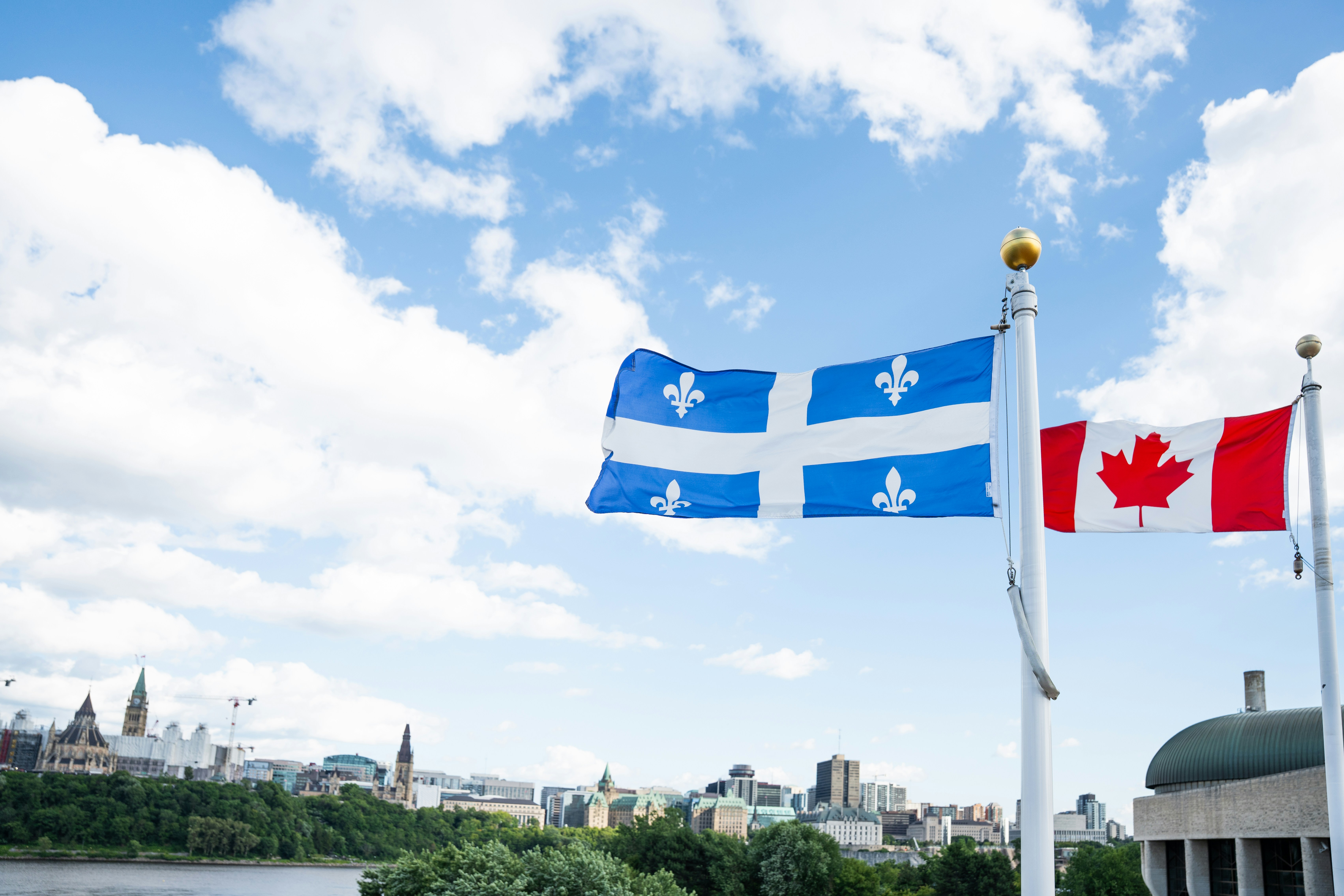 Flag Duo Over Ottawa River: Quebec Blue and Red Heritage
