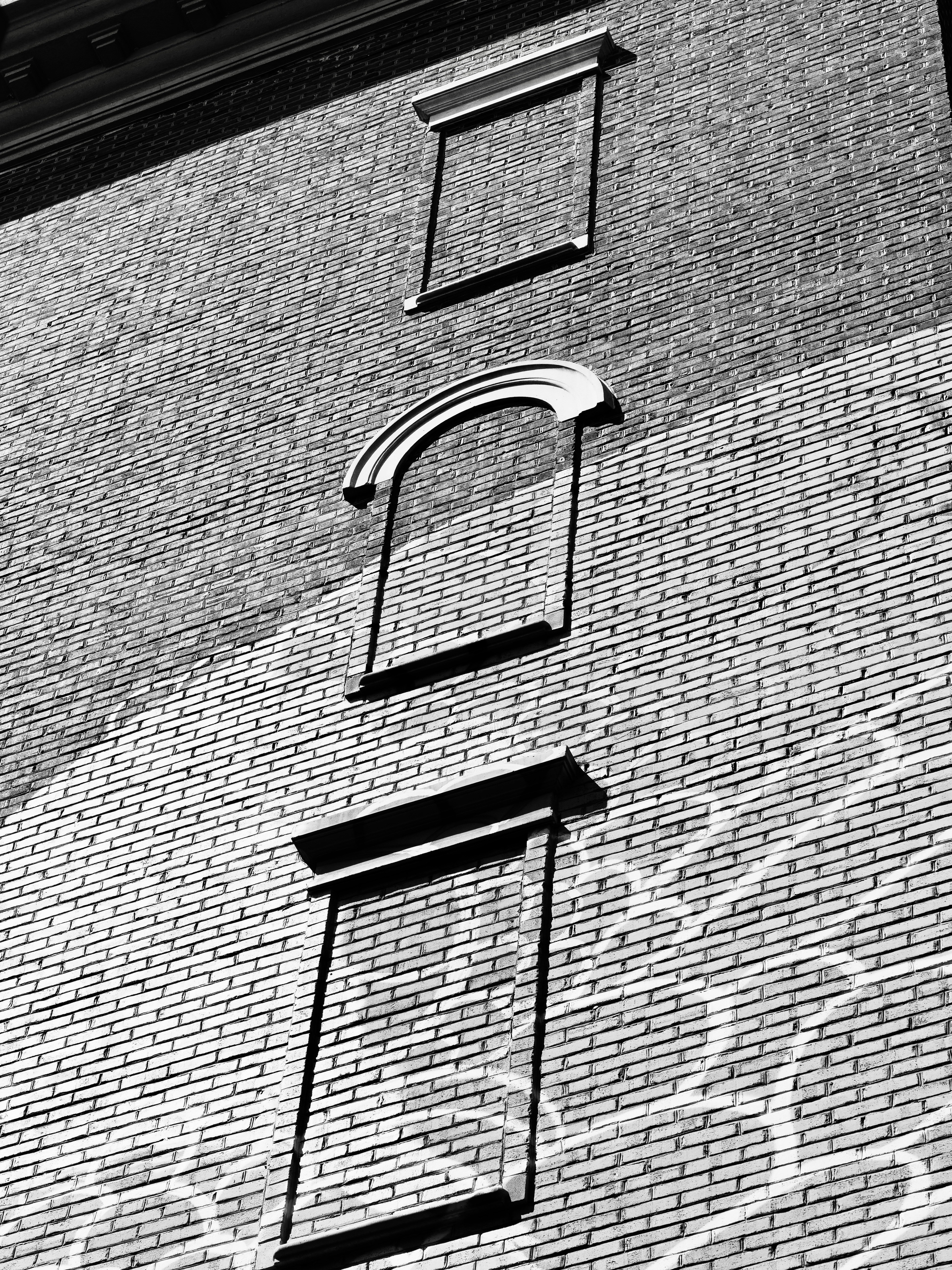 Brick Arches in Monochrome: Vertical Symmetry on a Narrow Facade