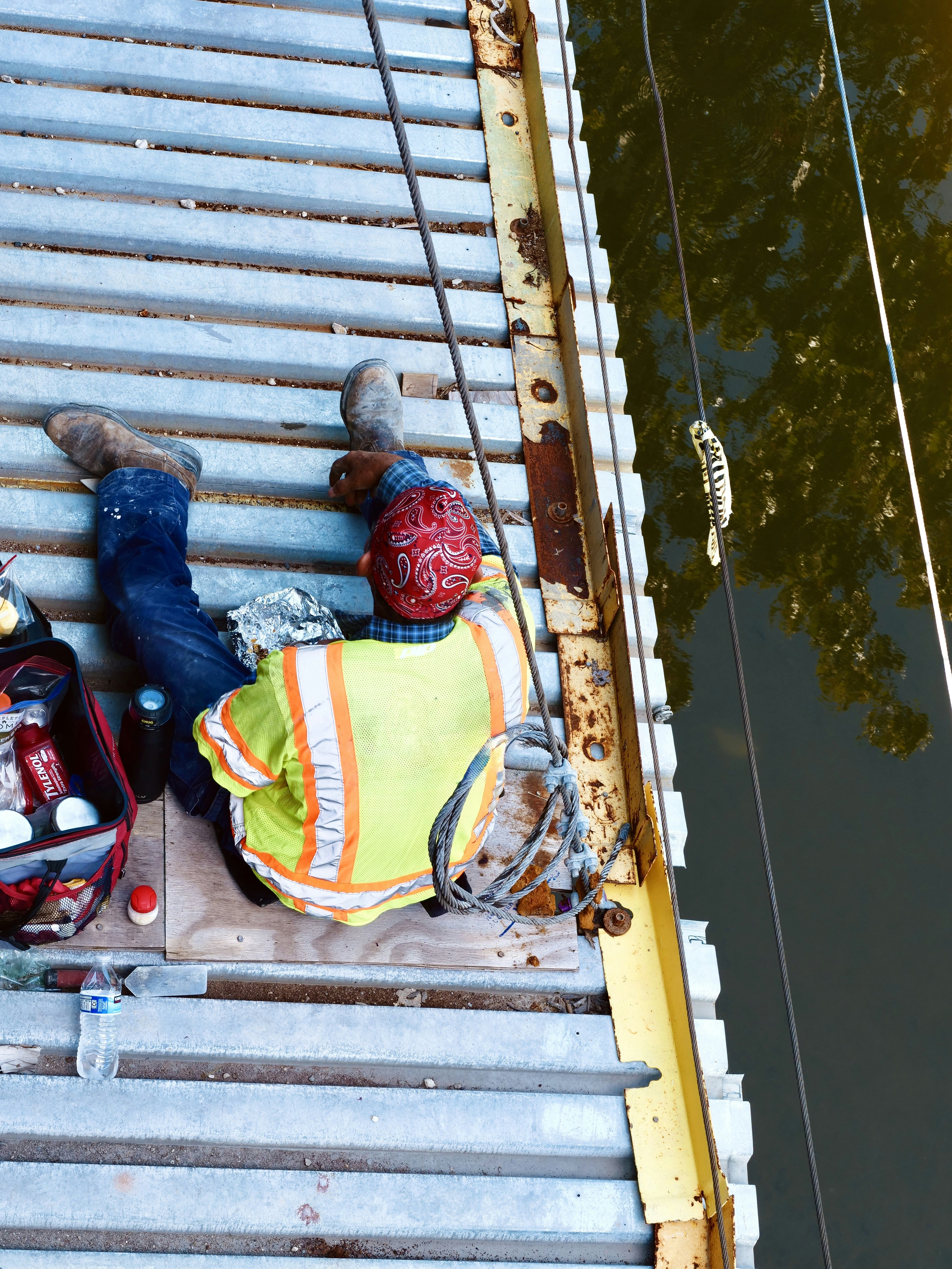 Worker on a Corrugated Platform Overlooking Waterway