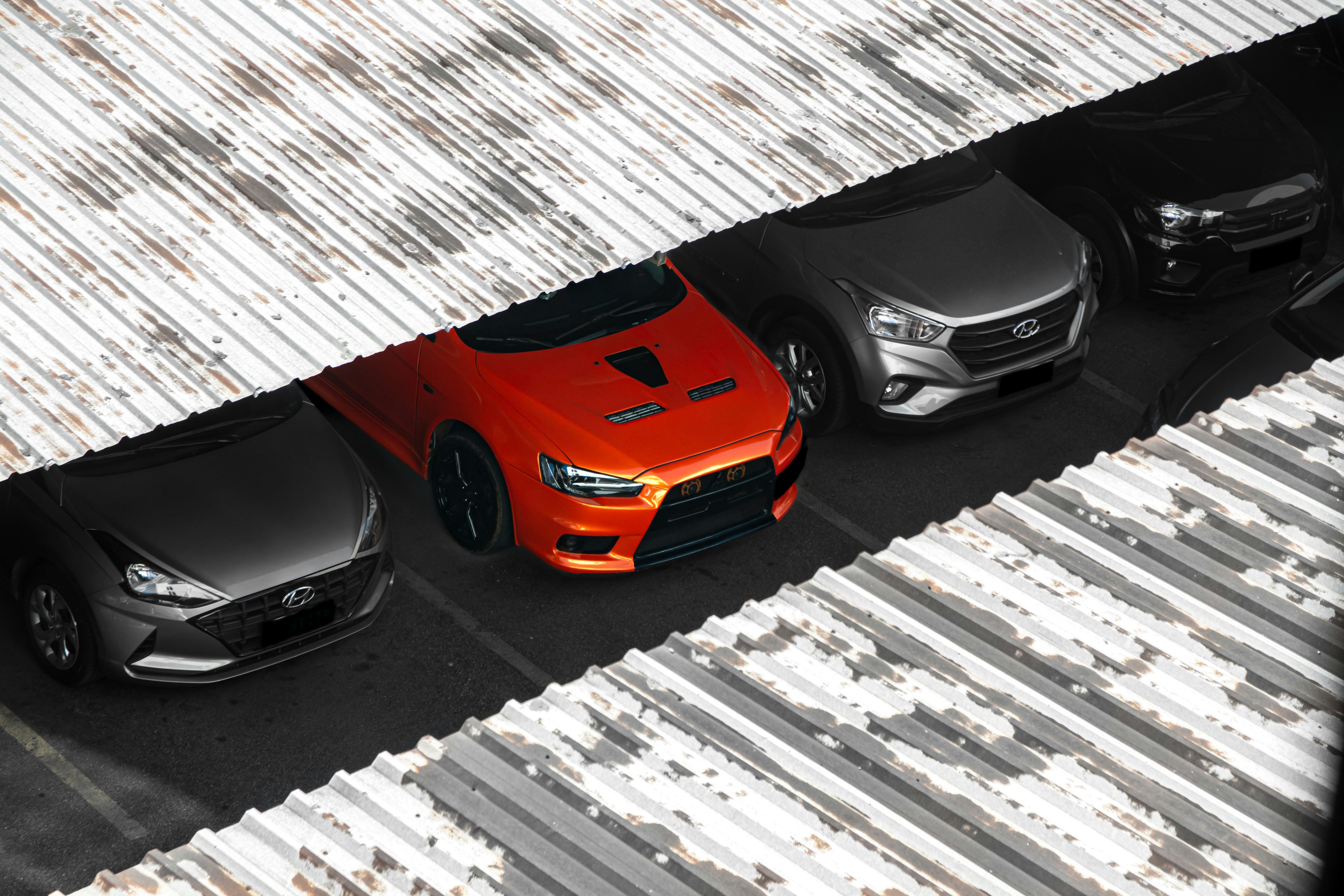 Mid-Row Blaze: An Orange Accent Among Monochrome Sedans