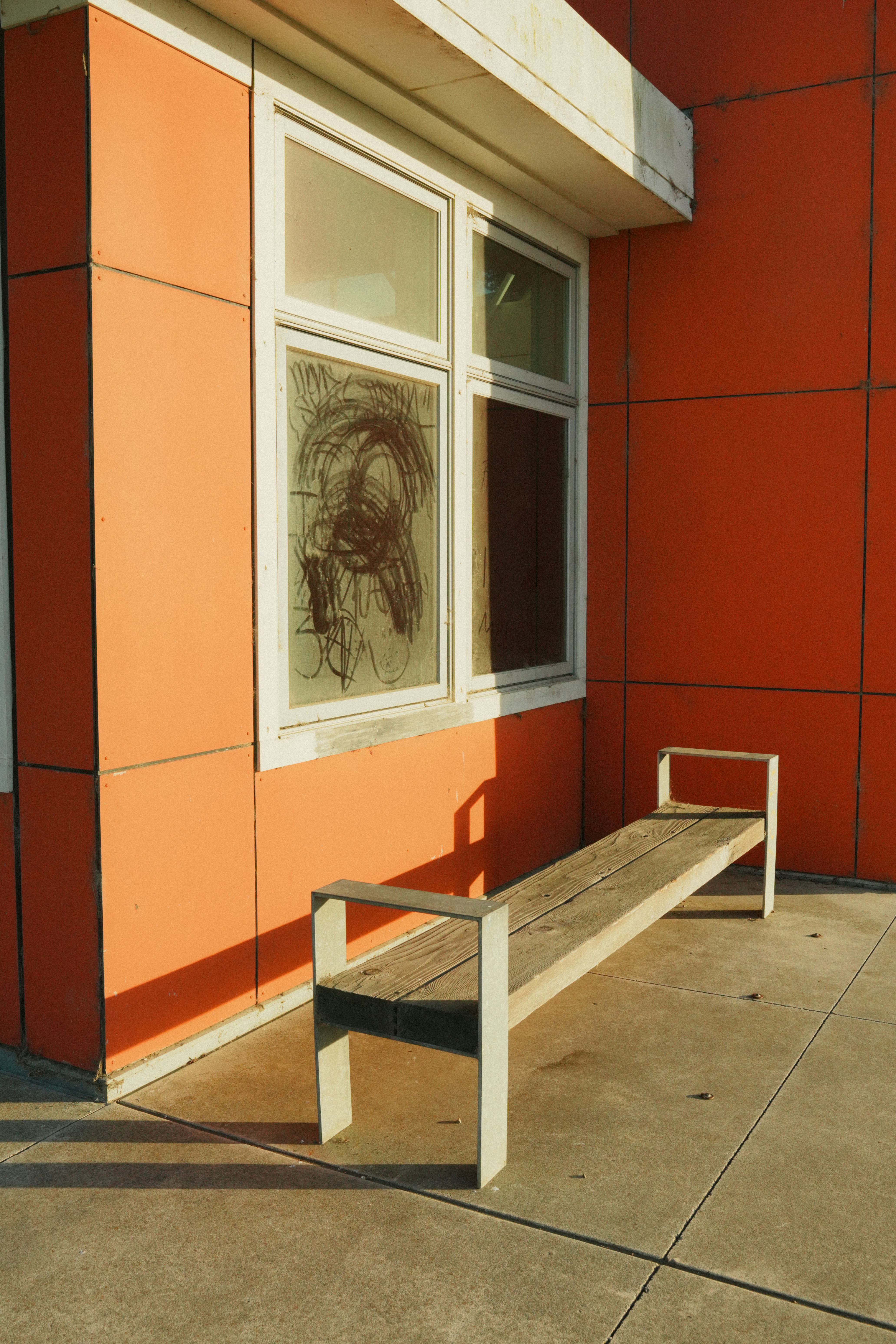 Orange Wall, Pale Bench, and Scribbled Window: Urban Minimalism in Light